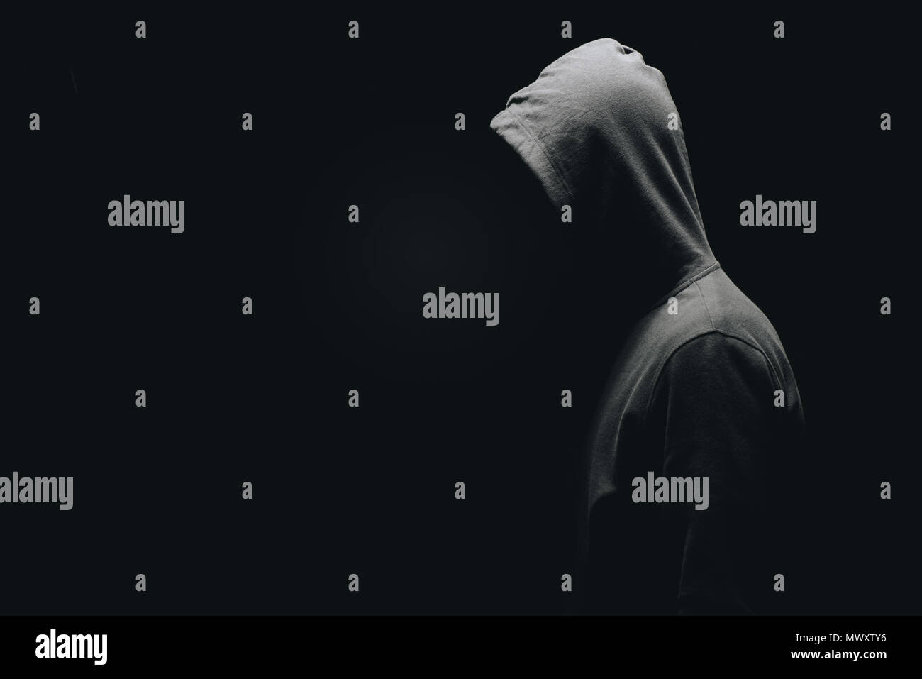 side view of unrecognizable man in man standing isolated on black Stock ...