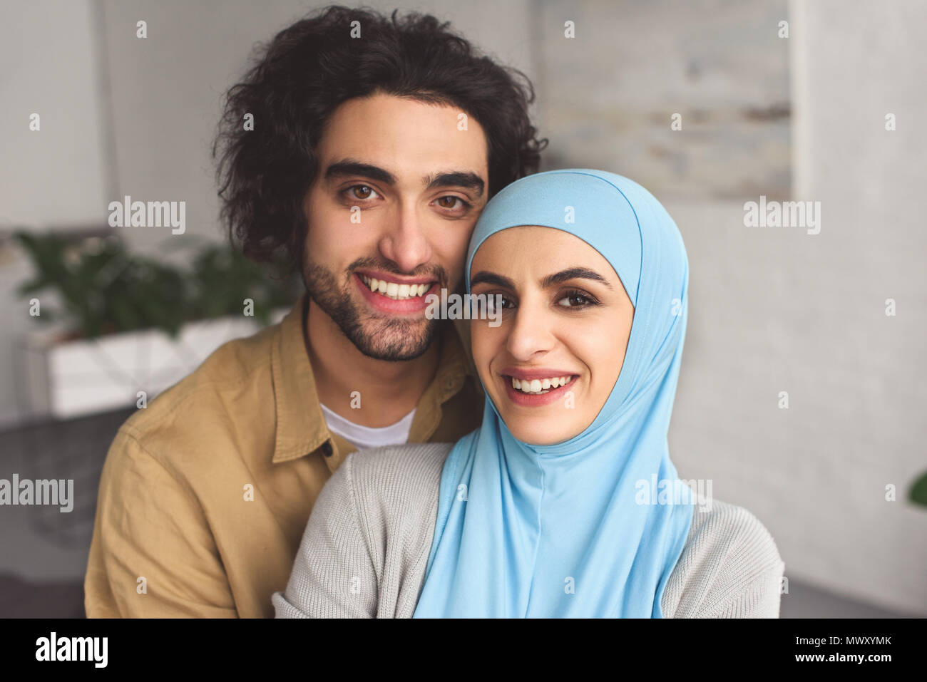 portrait of smiling muslim couple looking at camera at home Stock Photo ...