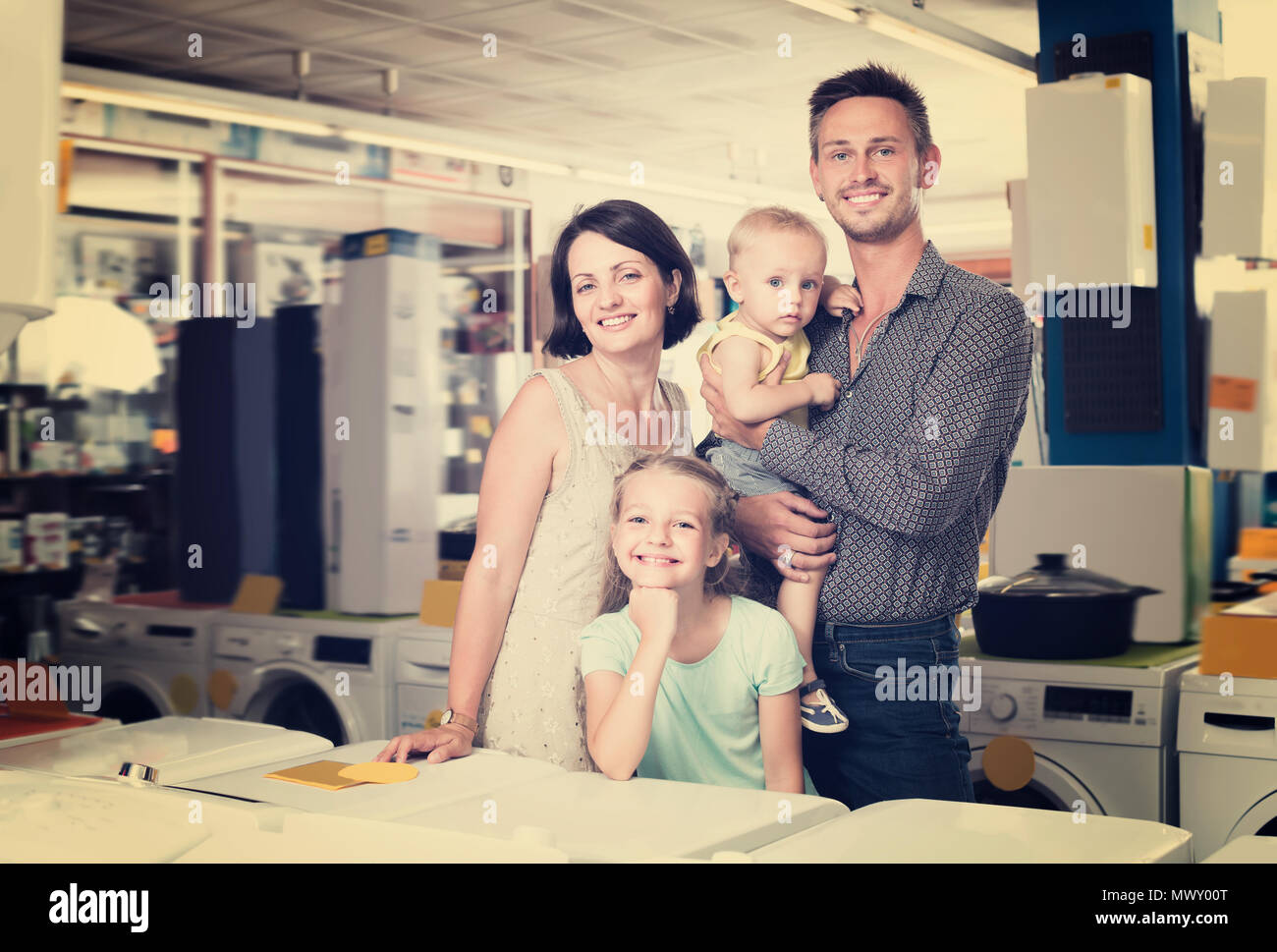 Friendly family with two children shopping together in shop of ...