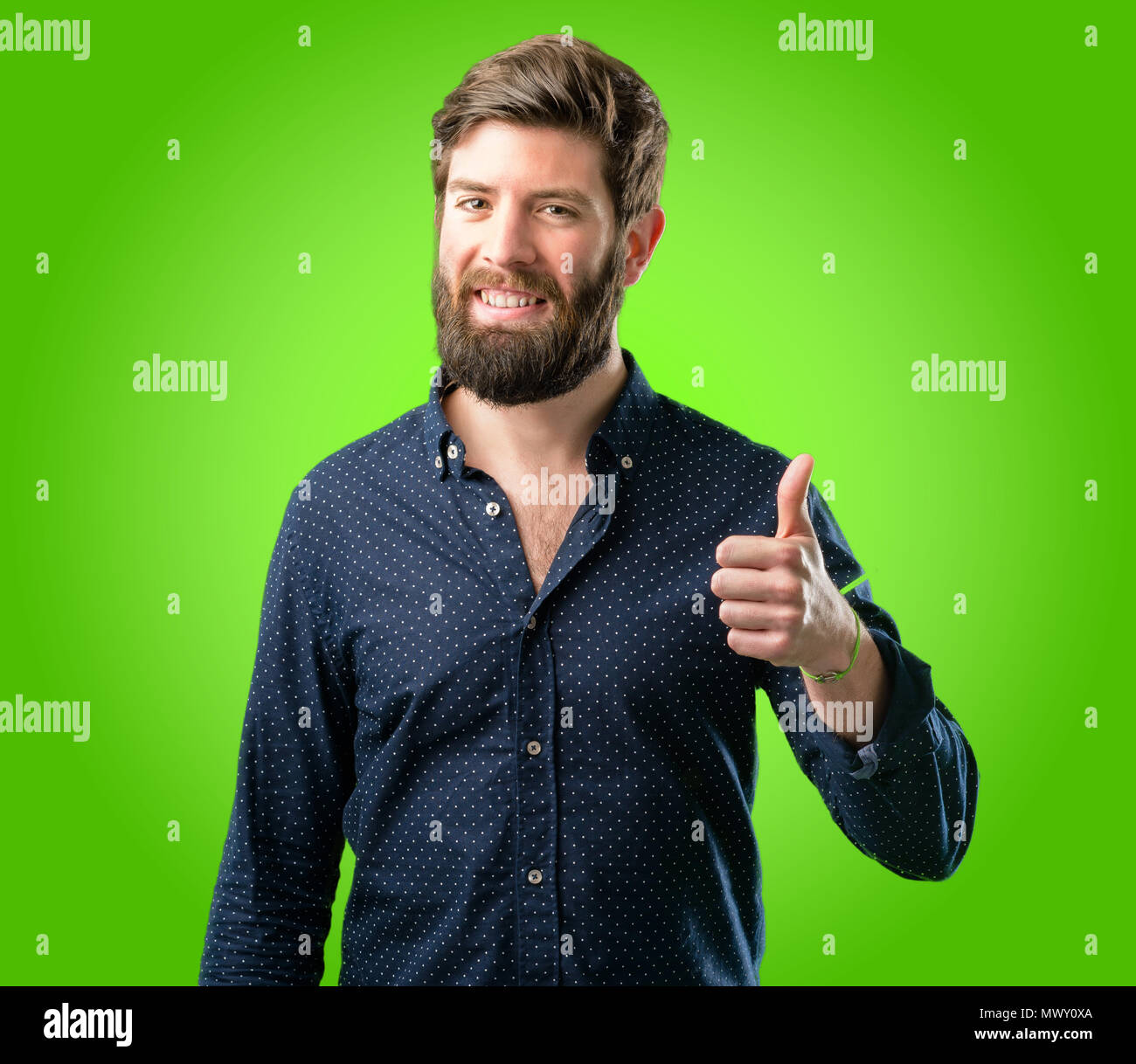Young hipster man with big beard smiling broadly showing thumbs up ...