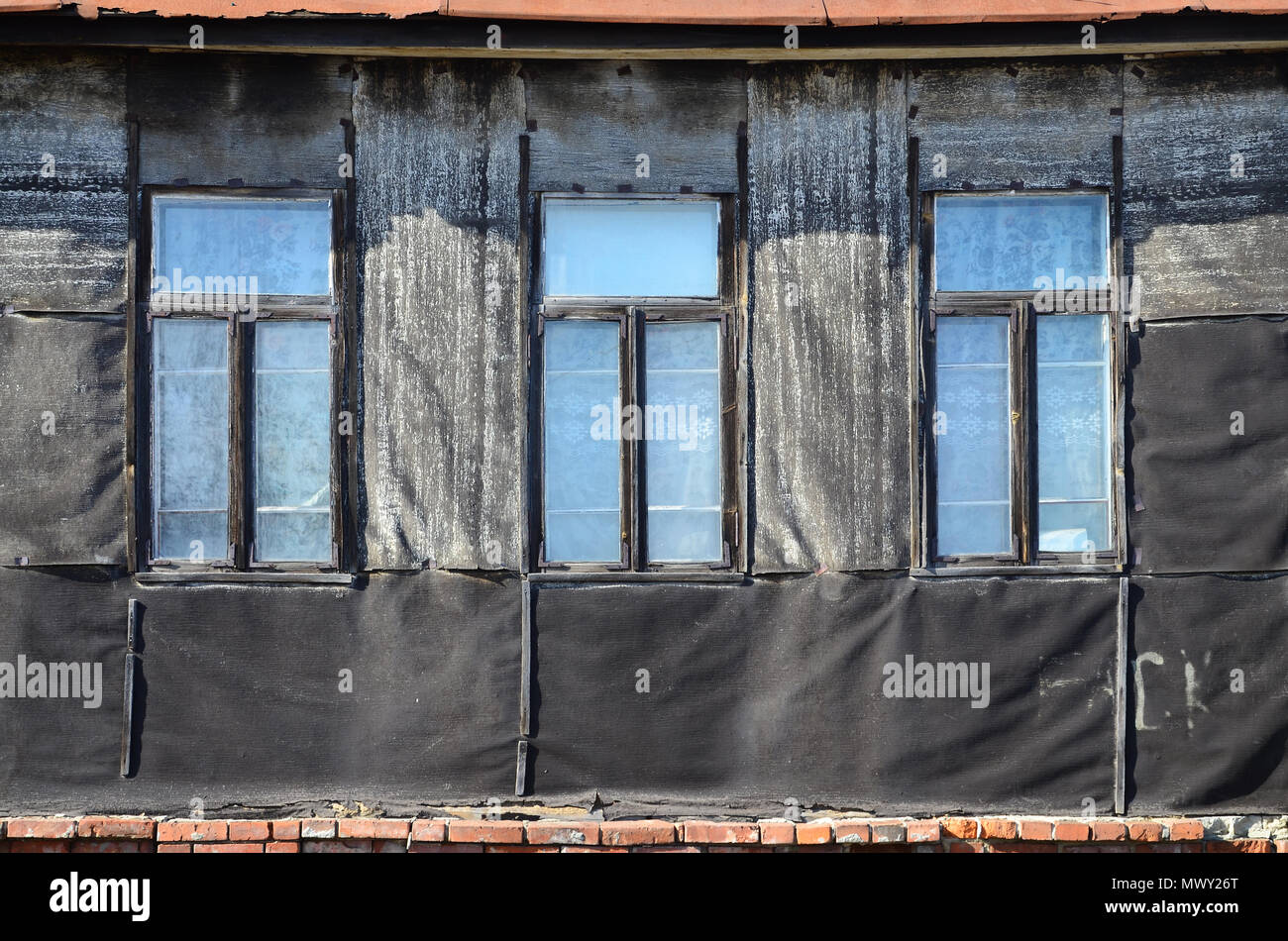 The texture of a brick wall with a few windows. Glazed windows in the ...
