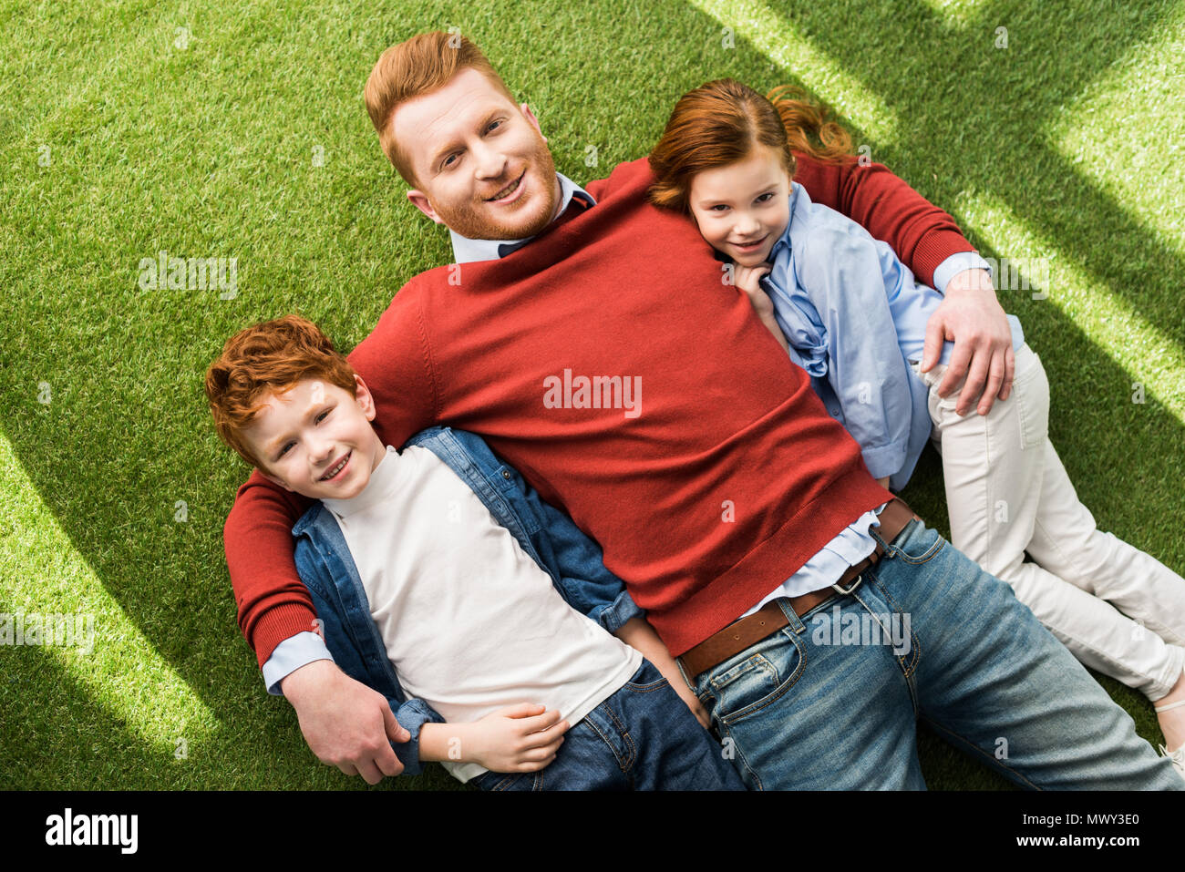 top view of happy father with adorable little kids lying together on ...