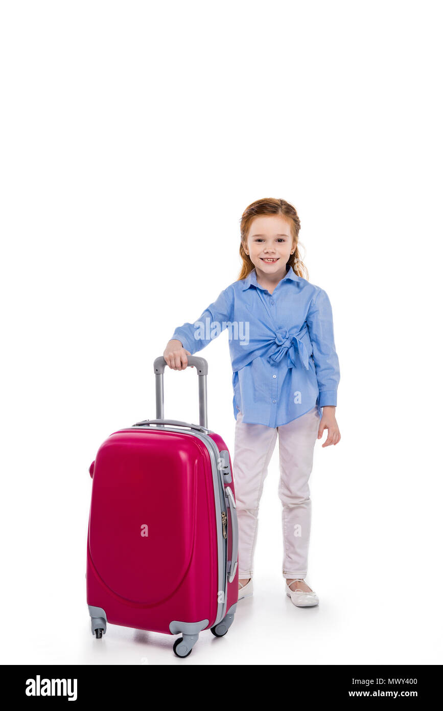 cute little child standing with suitcase and smiling at camera isolated ...