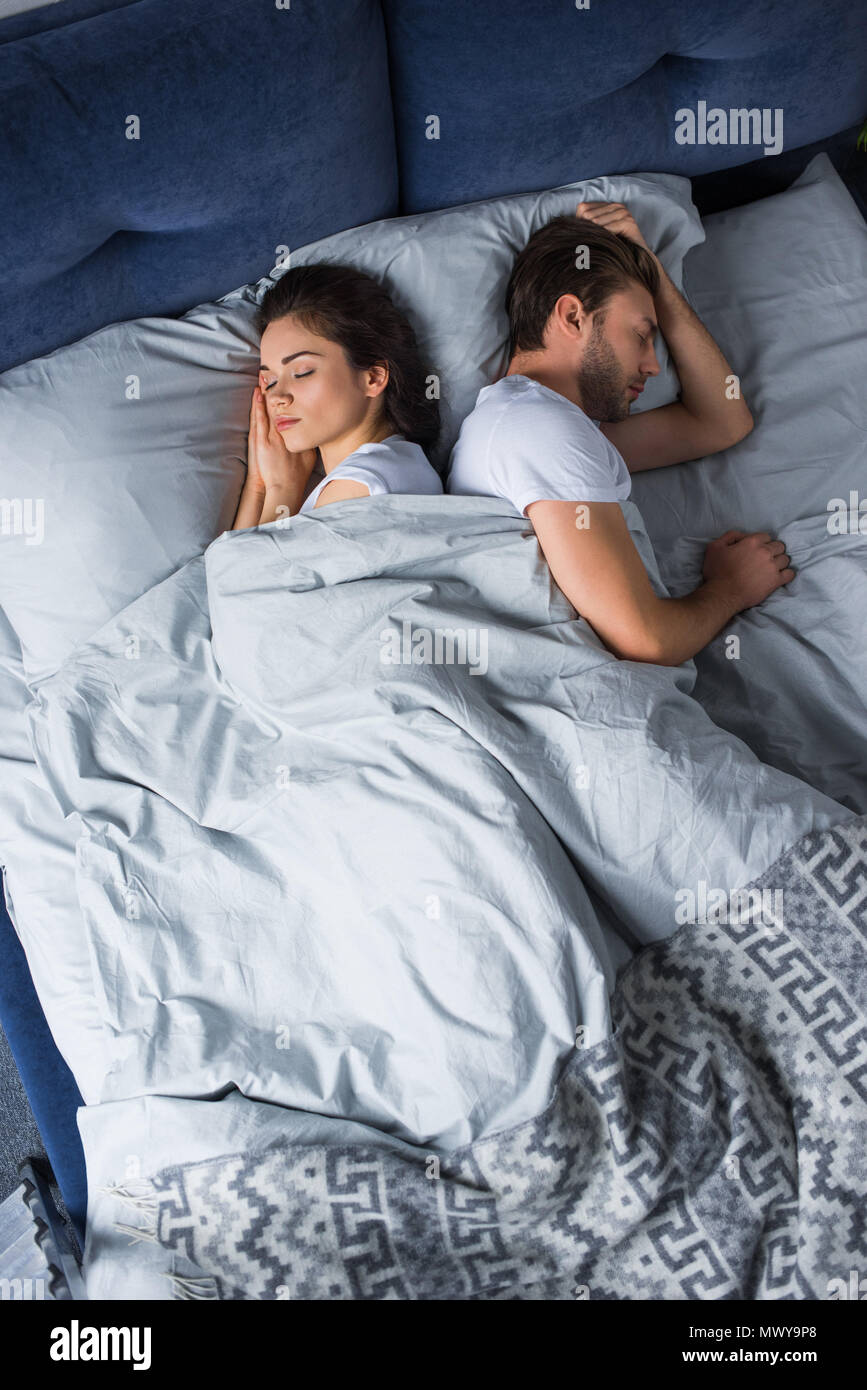 Sleeping man and woman lying in bed Stock Photo - Alamy