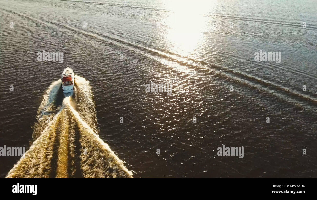 Small luxurious yacht. Fast moving speed boat floating on the lake ...