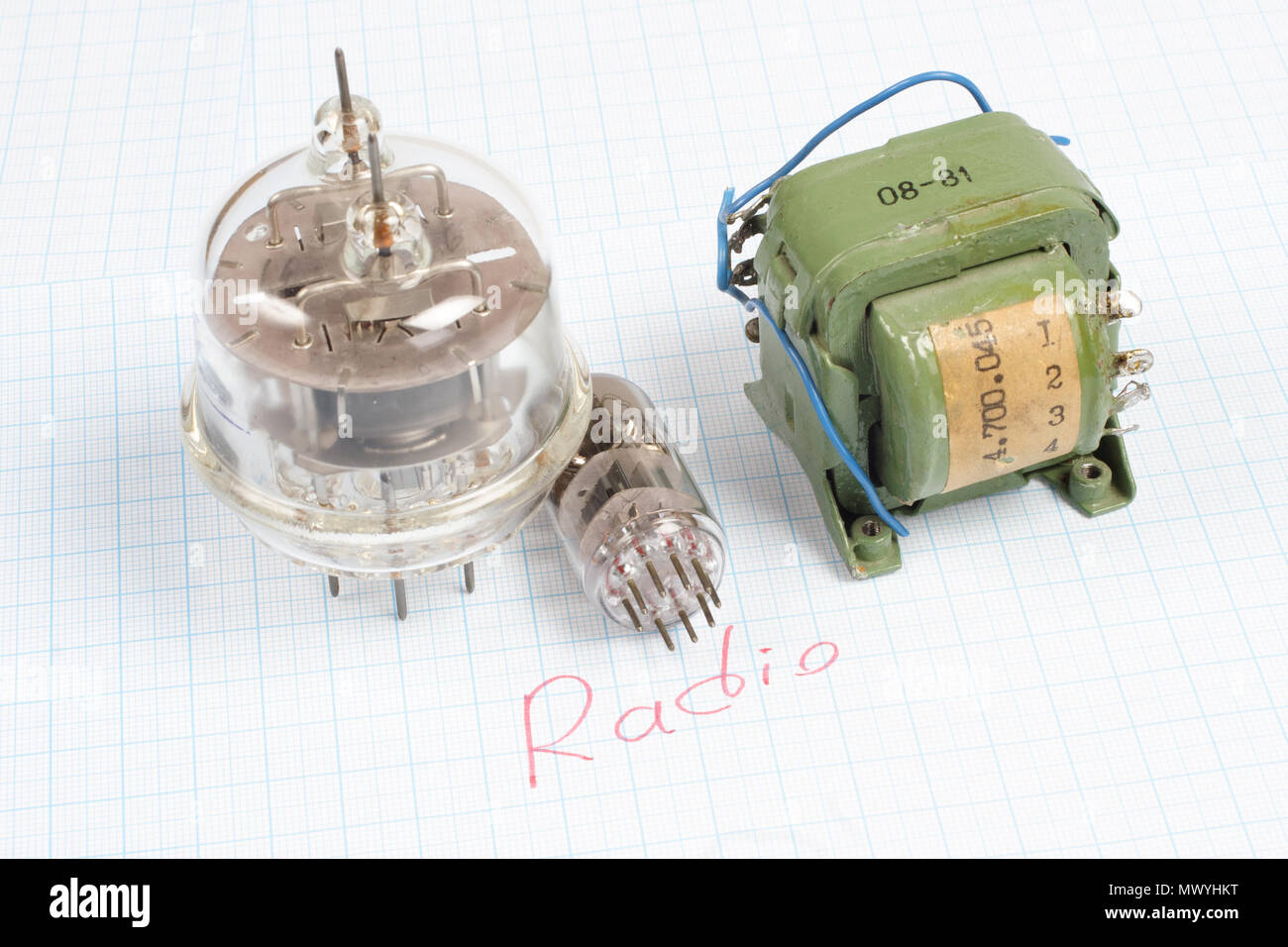 old vacuum tube (electron tube) and transformer on graph paper ...
