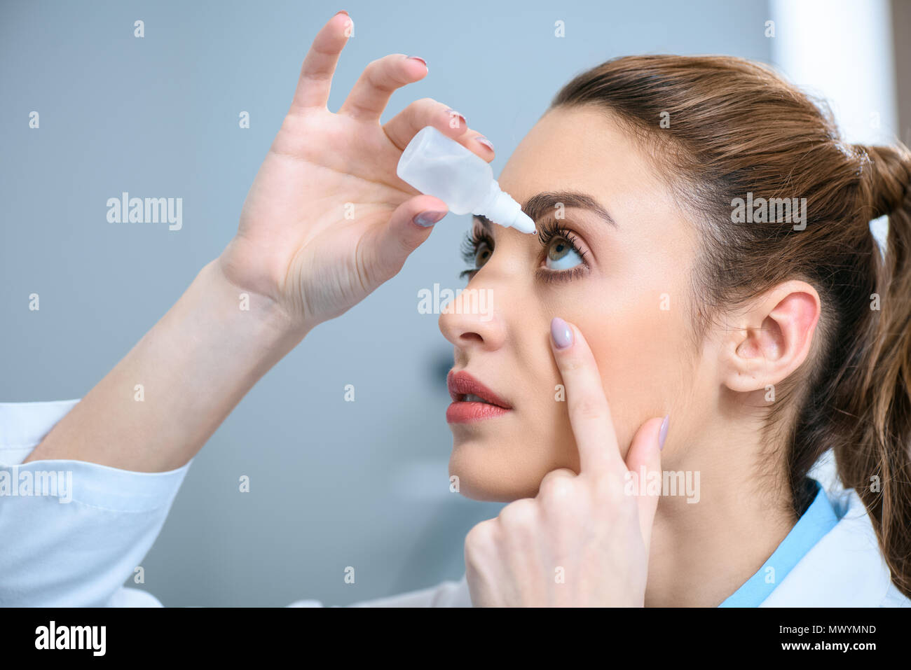female optometrist dripping eye drops Stock Photo - Alamy