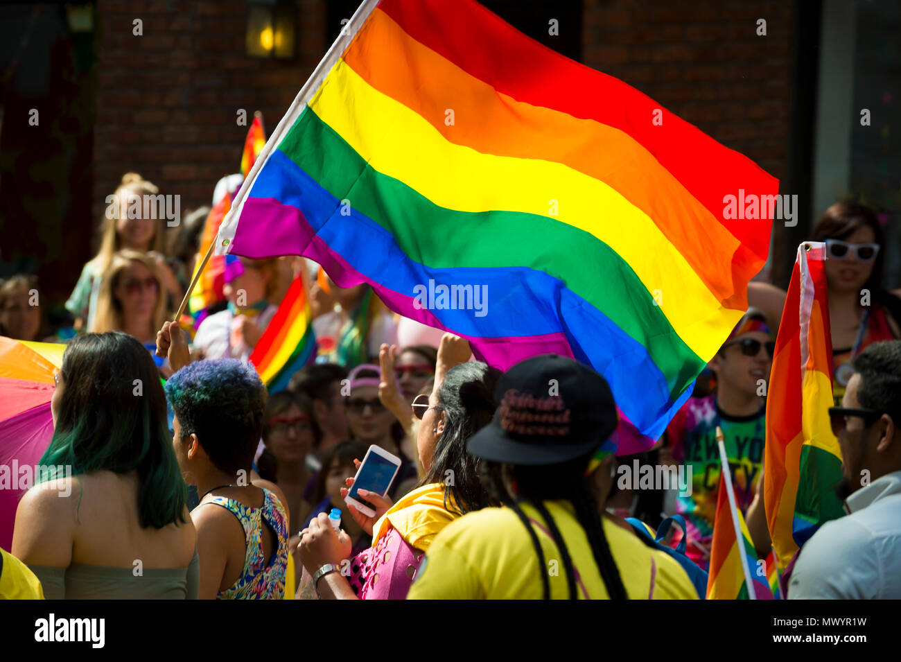NEW YORK CITY - JUNE 25, 2017: Supporters wave rainbows flags on the ...