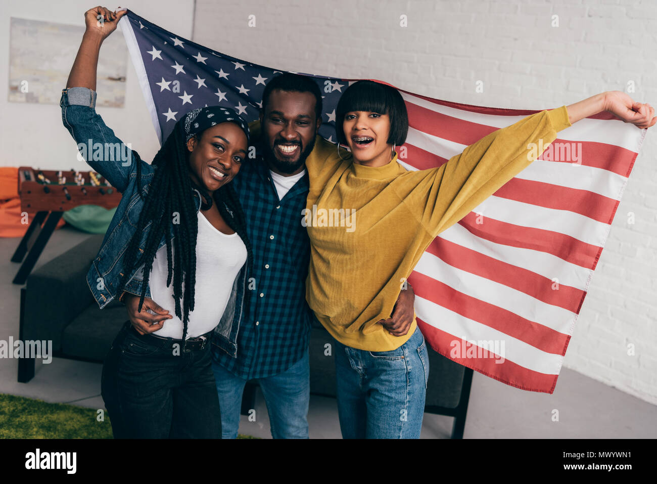 smiling young multiethnic friends standing with flag of USA Stock Photo ...