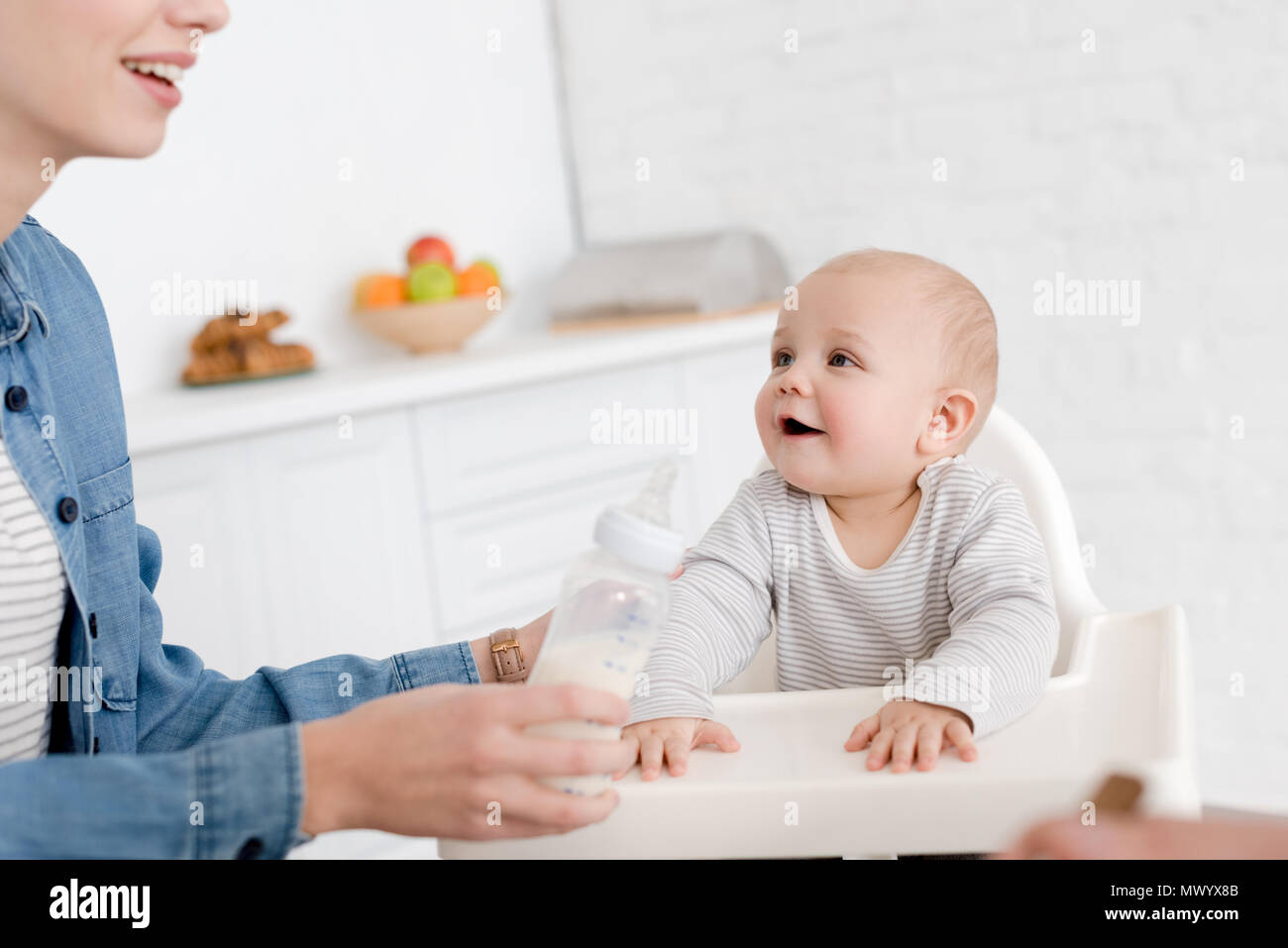 mother feeding little baby boy with milk on kitchen Stock Photo - Alamy
