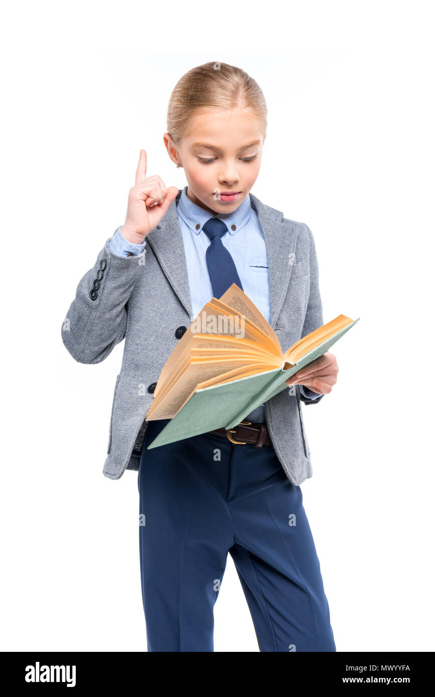 concentrated schoolgirl in reading book and pointing up, isolated on ...