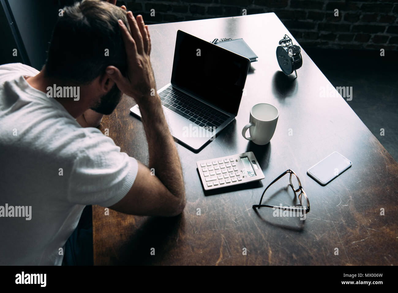 partial view of stressed and overworked freelancer remote at table with ...