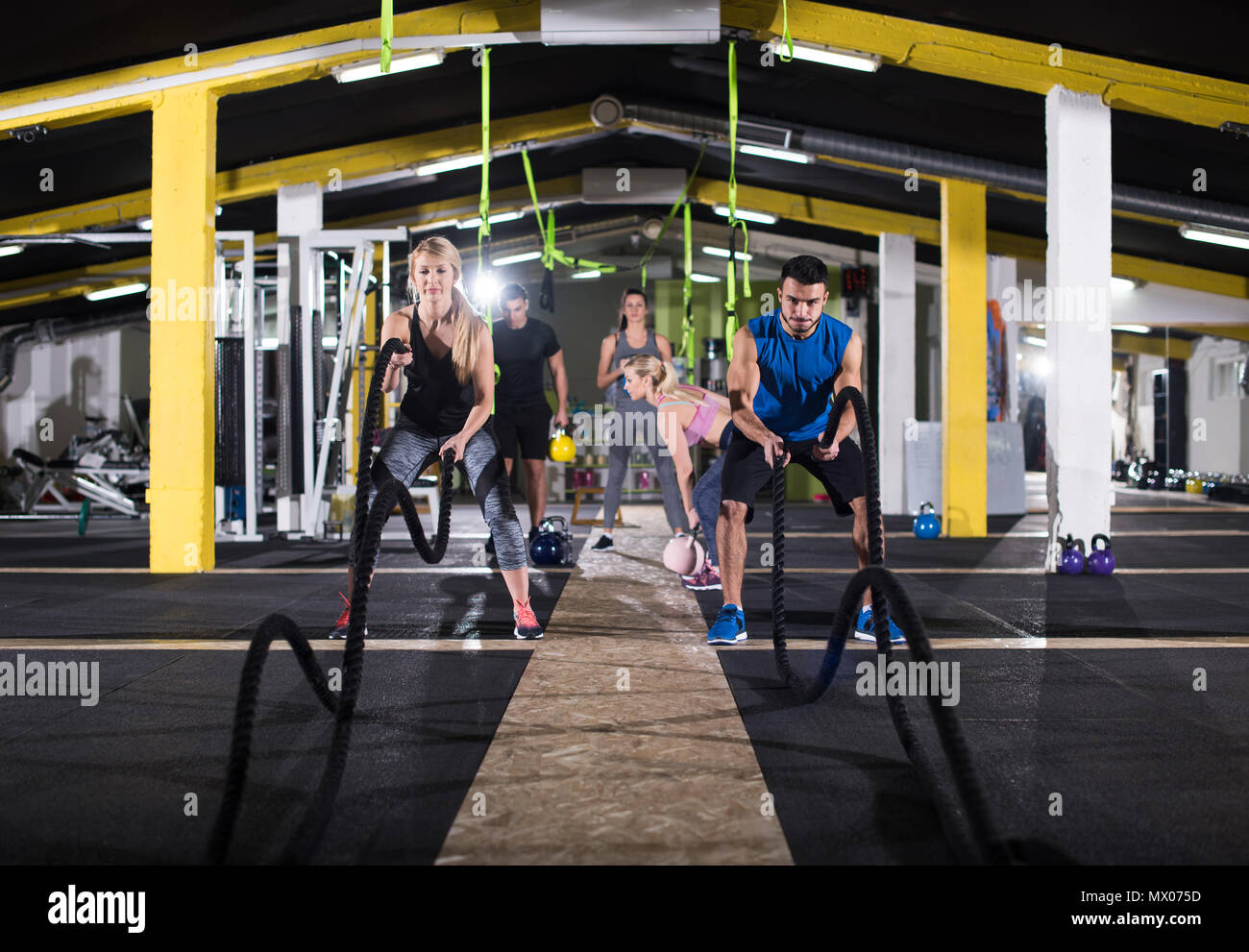 young fit sports couple working out in functional training gym doing ...