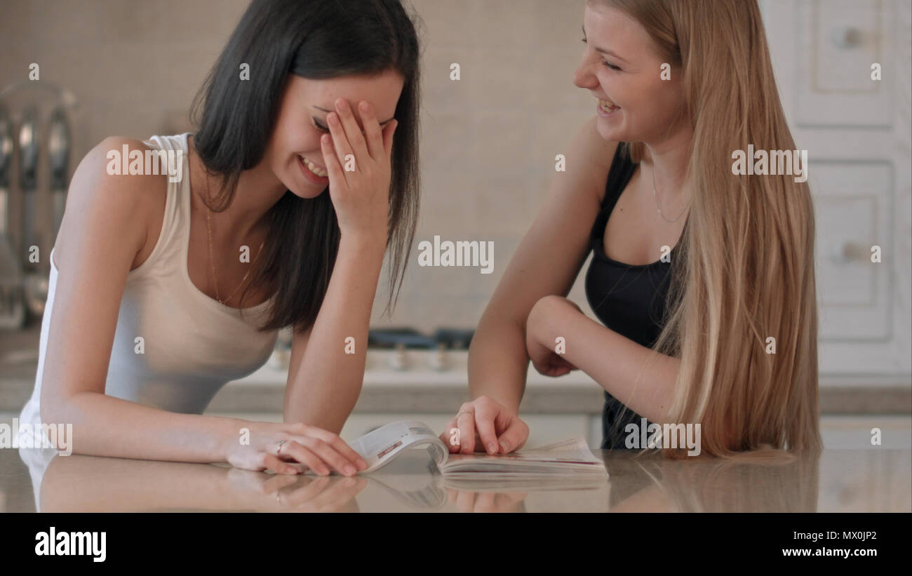 Two Girls reading fashion Magazine. People. Professional shot in 4K ...