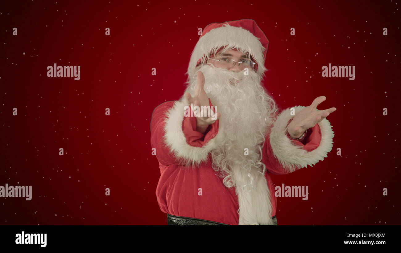 Santa Claus dancing in costume on red background with snow ...