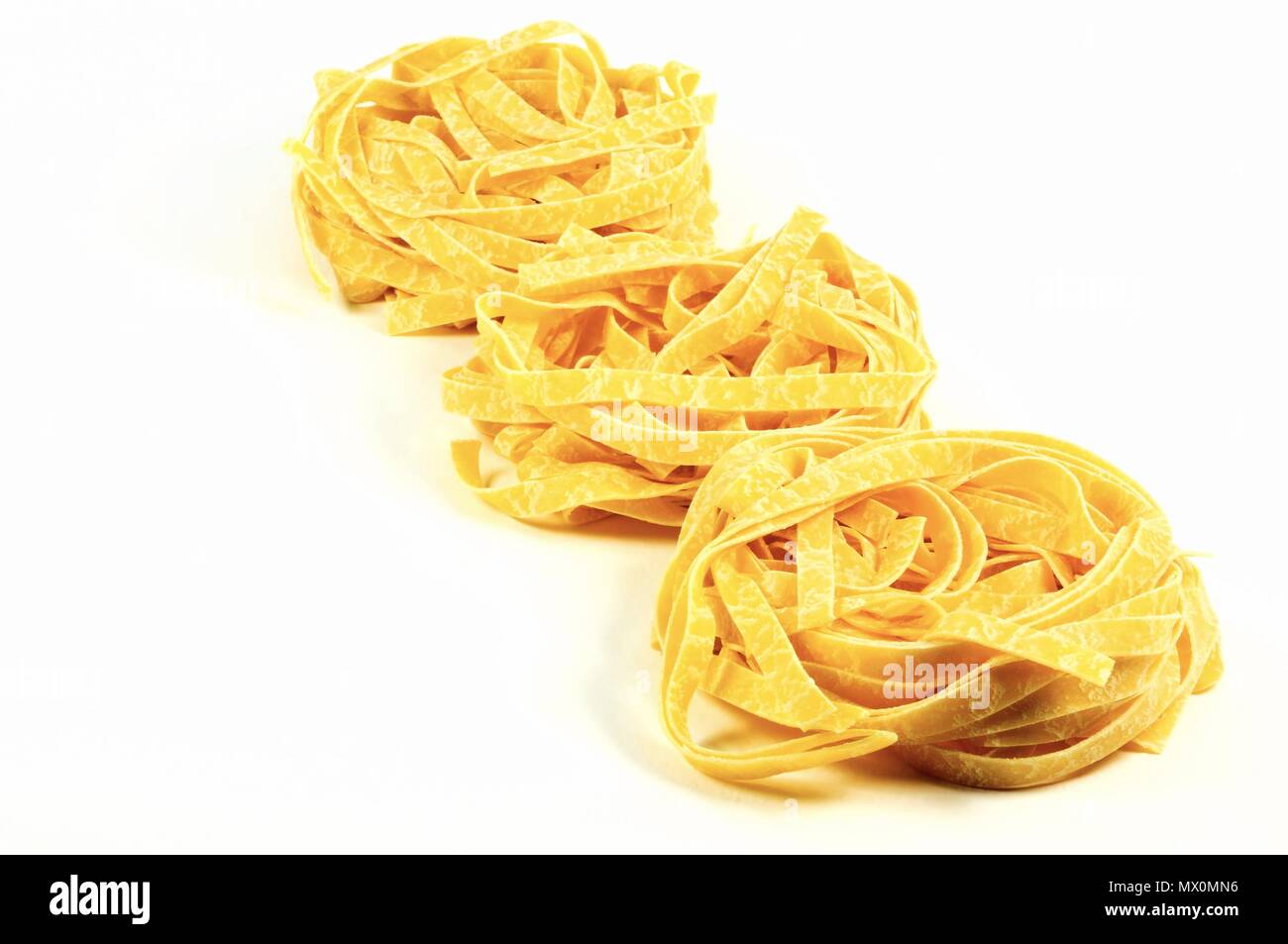 Three traditional italian pasta tagliatelle nests isolated on white ...