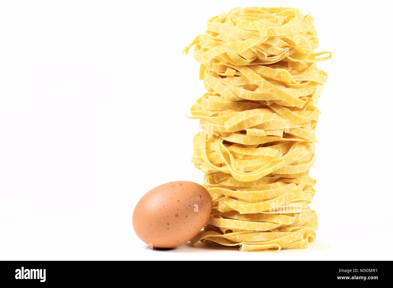 Stack of traditional Italian pasta tagliatelle nests with egg isolated ...