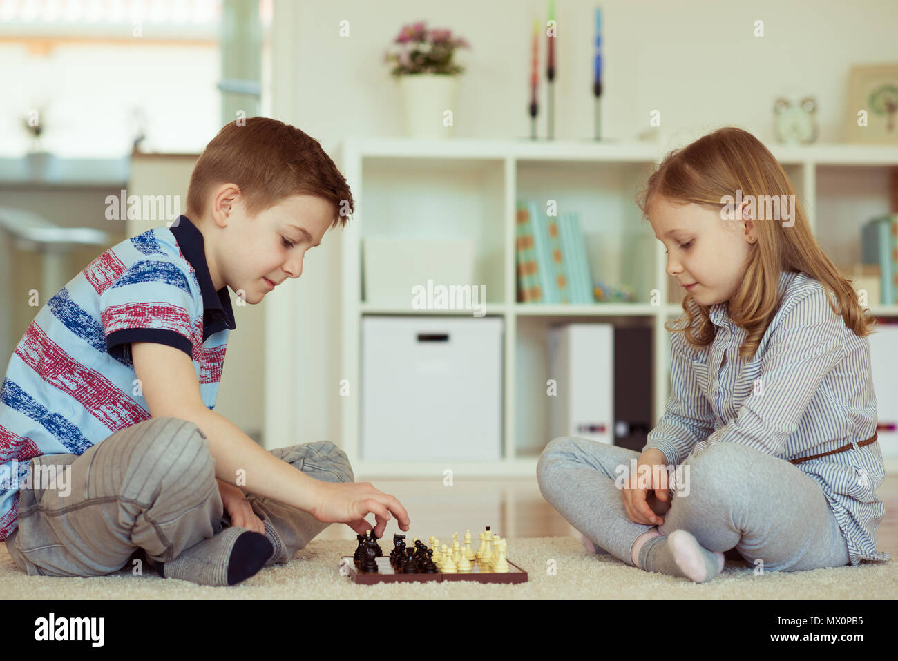 Two little children playing chess at home emotionally Stock Photo - Alamy