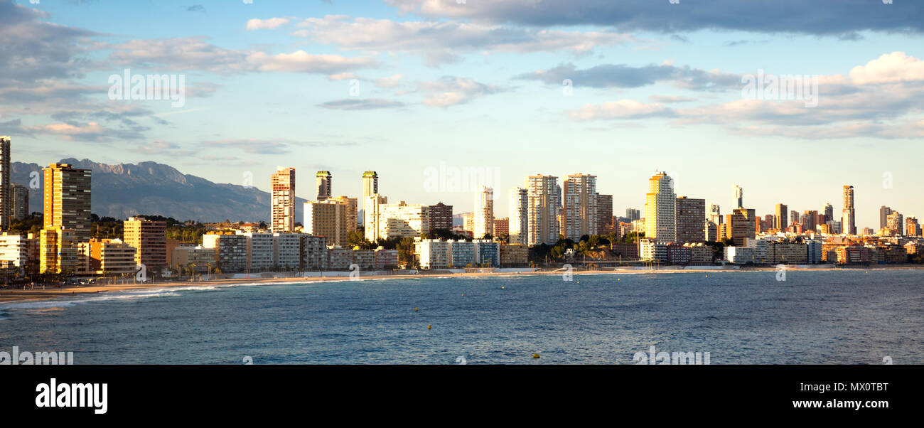 sunny sandy beaches of Benidorm with modern housing and mountains on ...