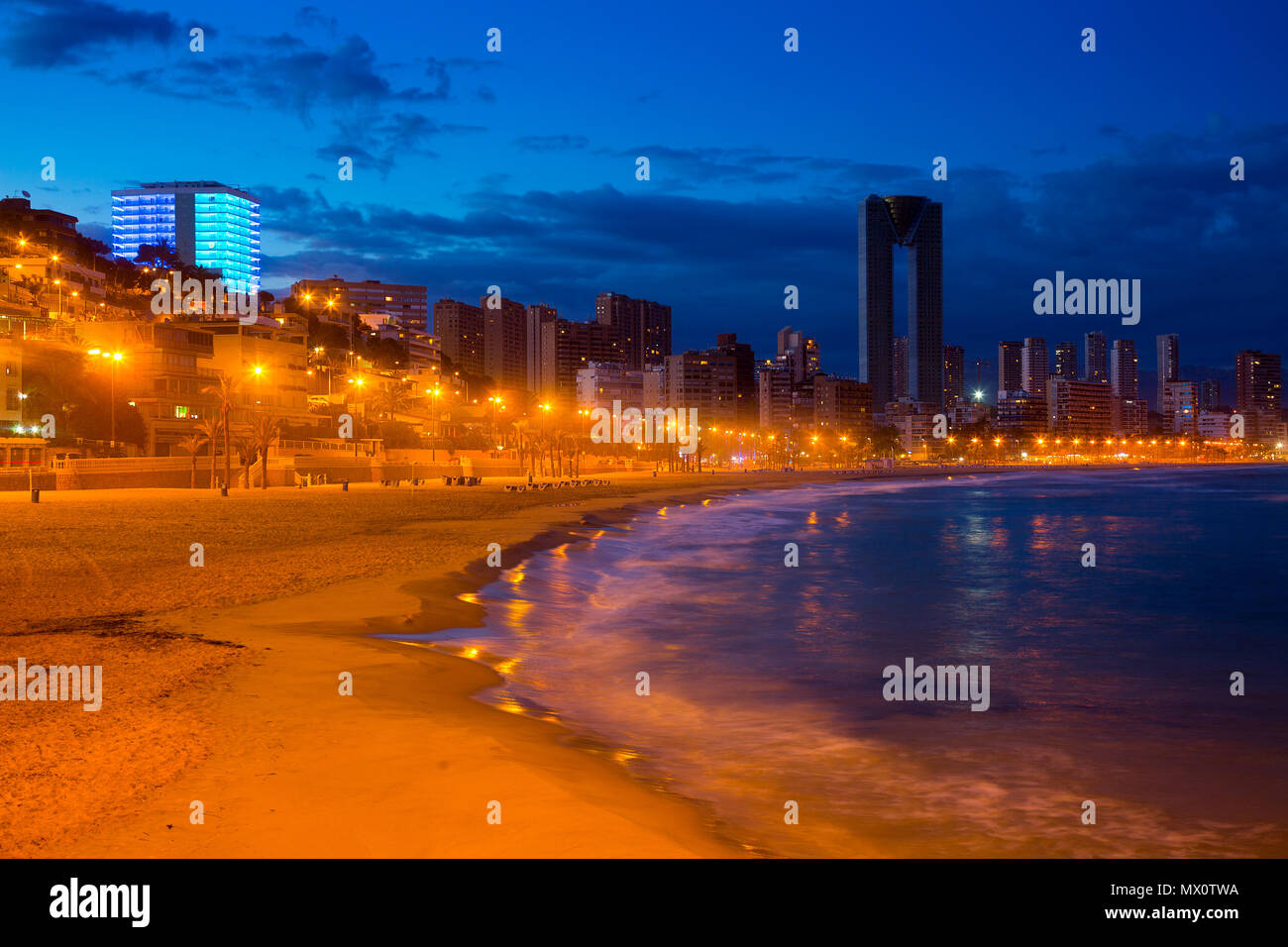 Nighttime illuminated Benidorm cityscape with sandy beaches and modern ...