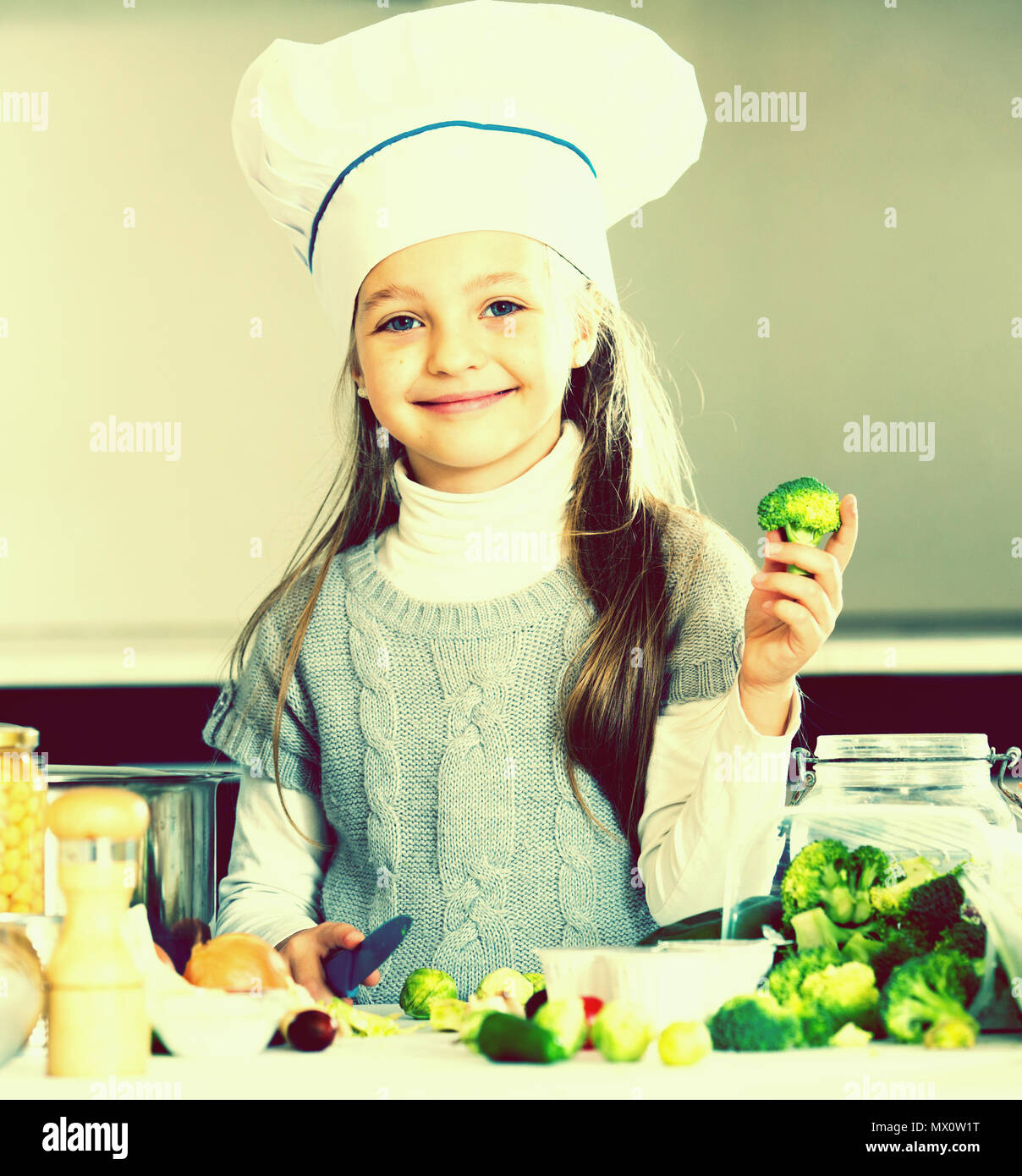 Portrait of cute little girl in cook cap cooking veggies Stock Photo ...