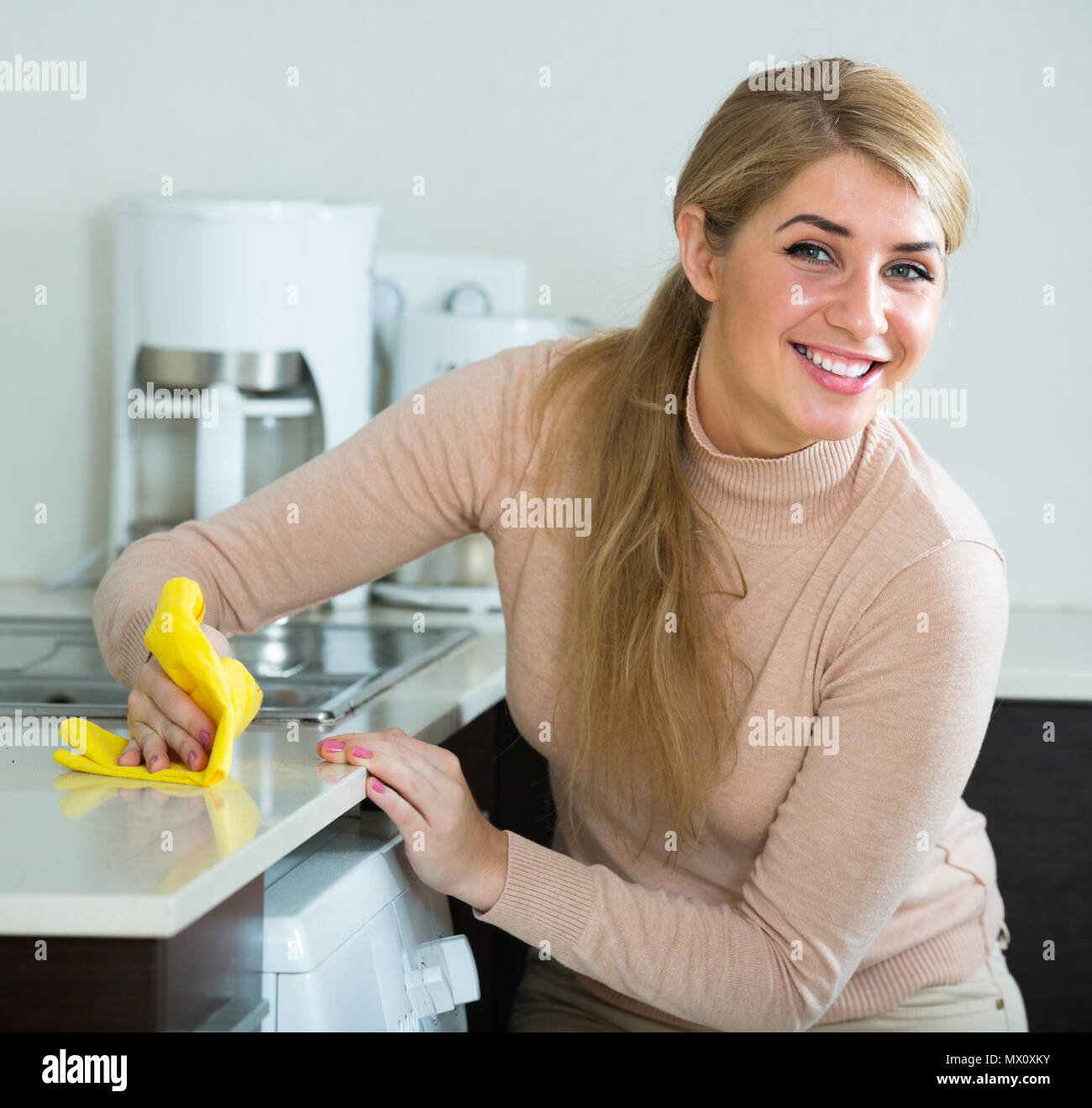 Joyful woman cleaning kitchen hi-res stock photography and images - Alamy