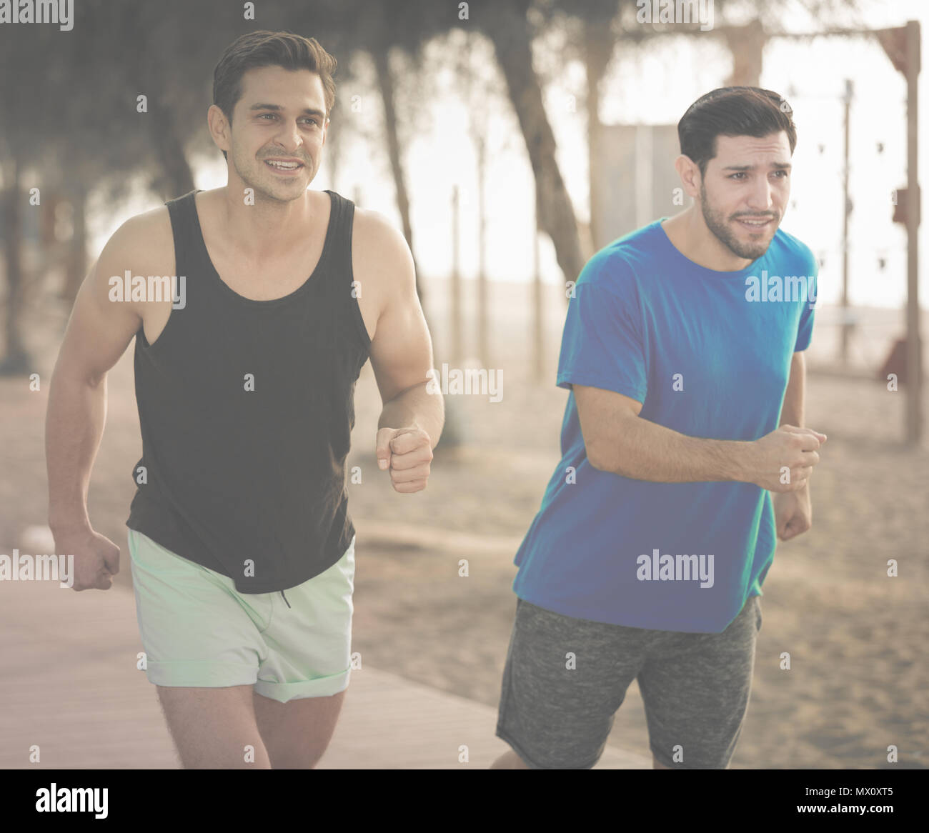 Adult men are jogging together in the park near ocean Stock Photo - Alamy