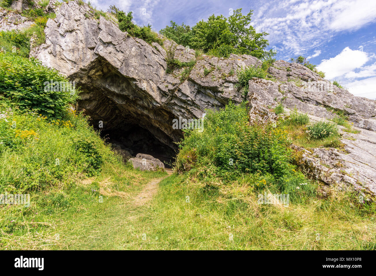 cave entry at summer with niche sky and clouds Stock Photo - Alamy