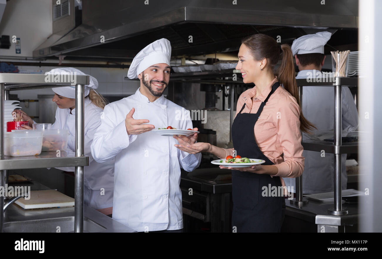 Head chef checking dishes in kitchen of restaurant before serving ...