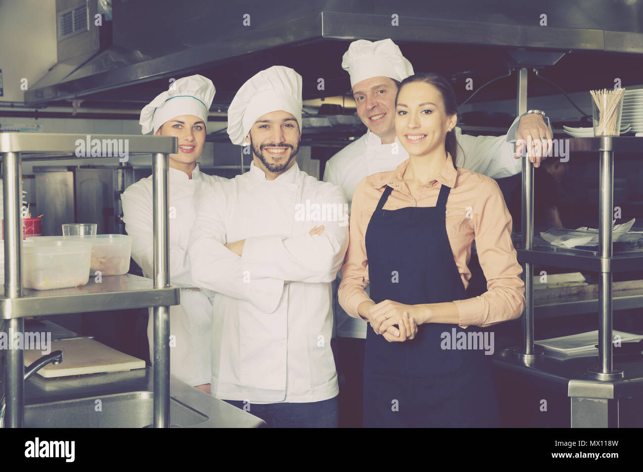 Team of restaurant staff posing together in modern professional kitchen ...