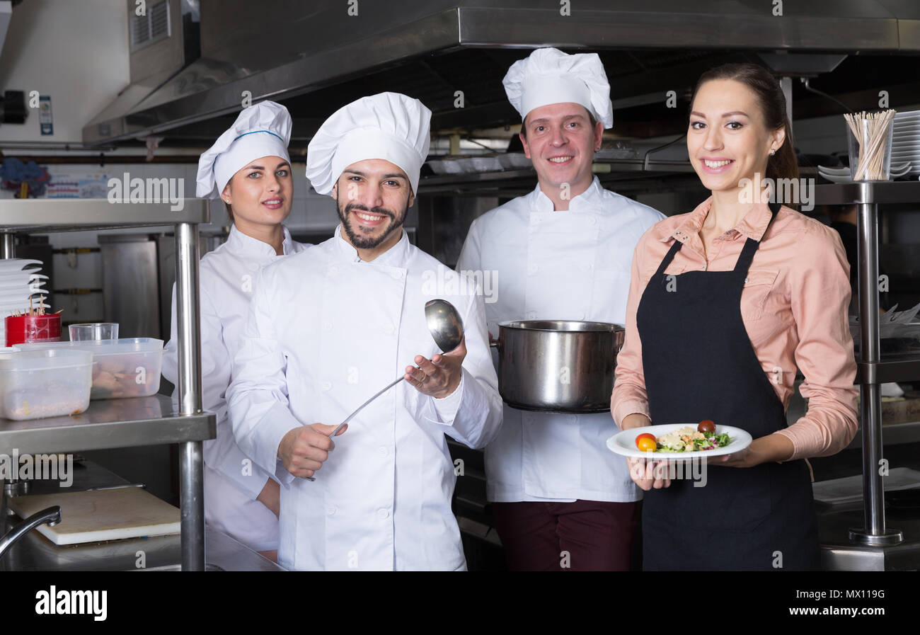 Team of restaurant staff posing together in modern professional kitchen ...