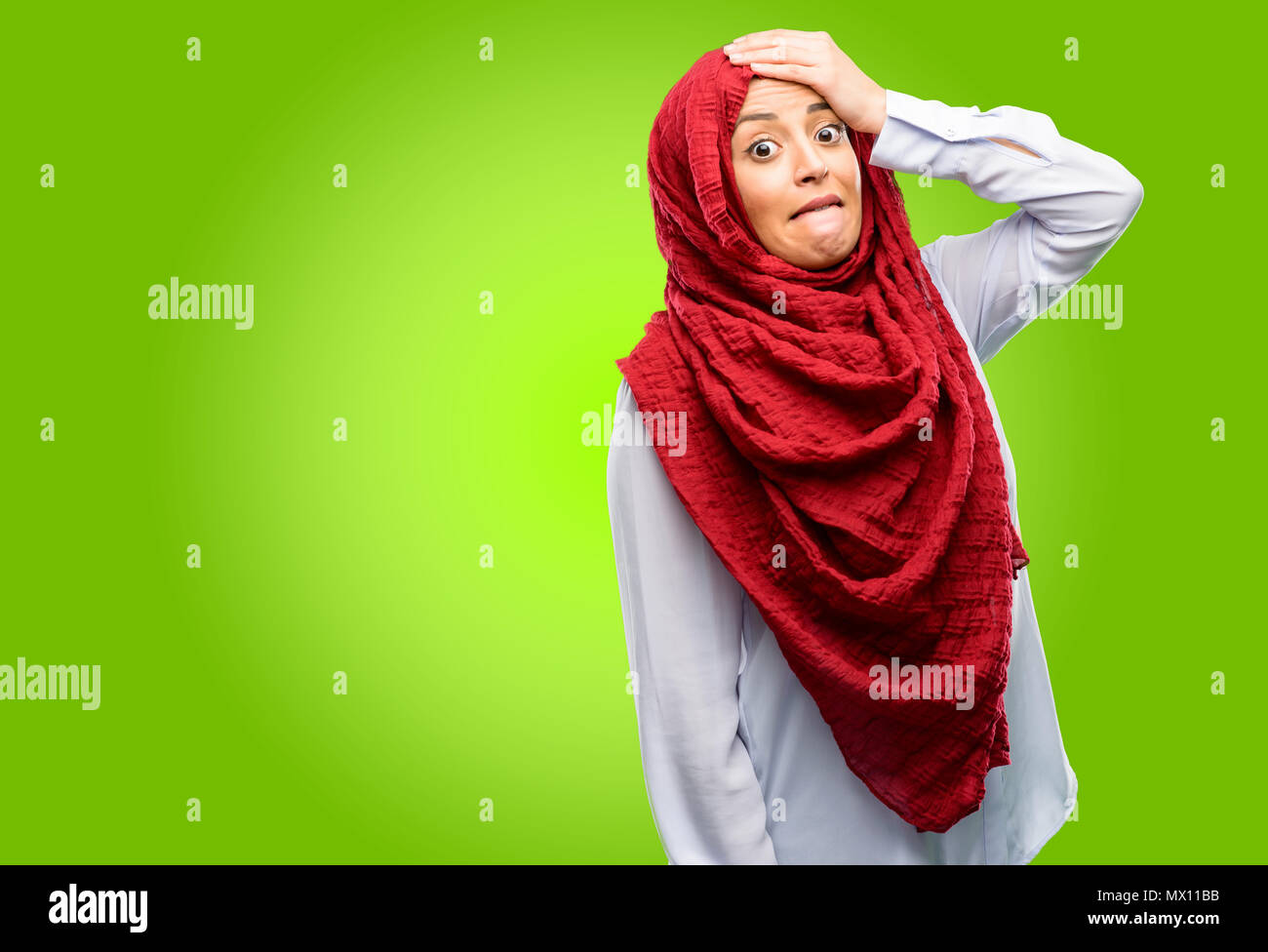 Young arab woman wearing hijab terrified and nervous expressing anxiety ...