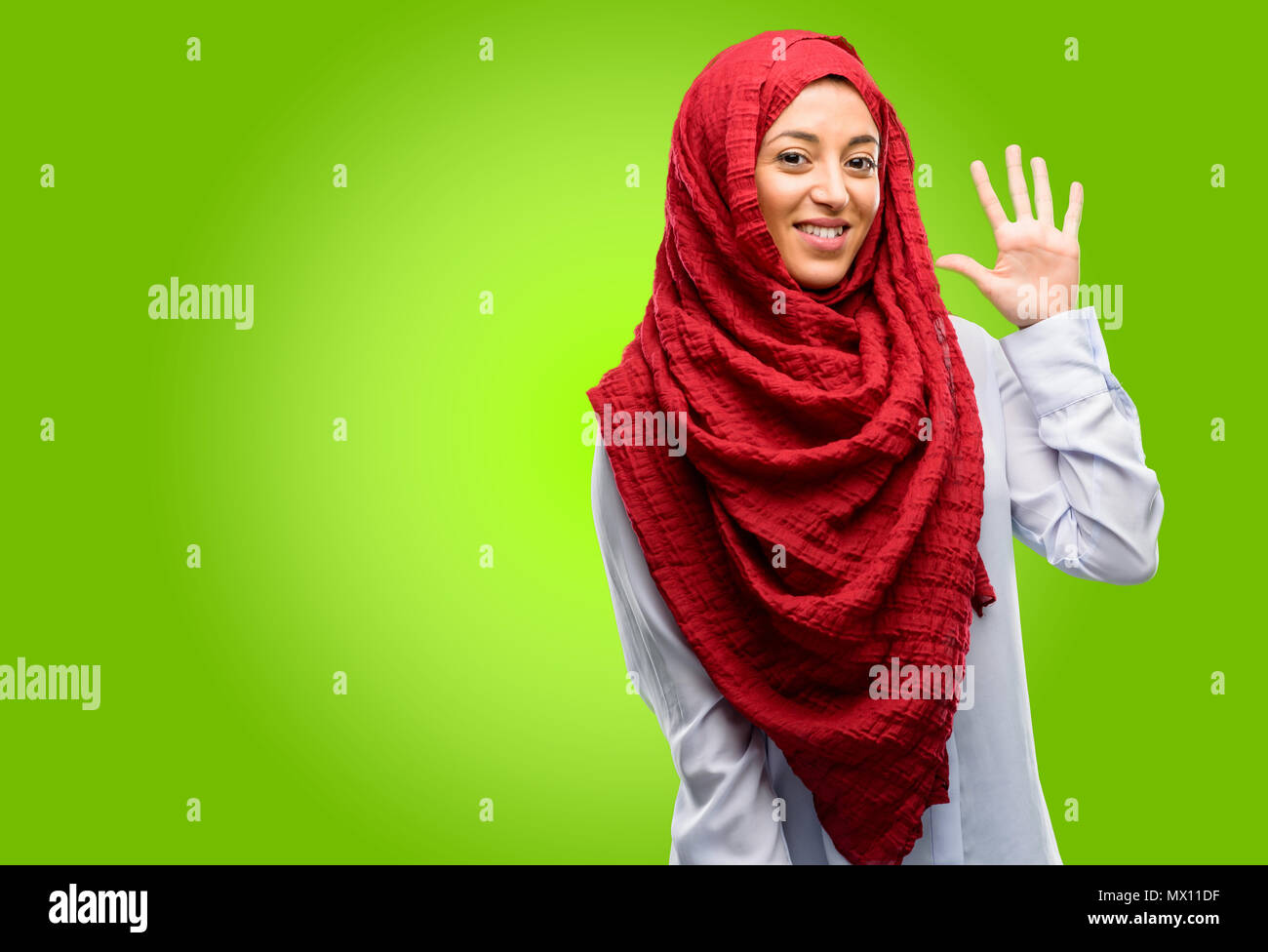 Young arab woman wearing hijab raising his finger, is the number five ...