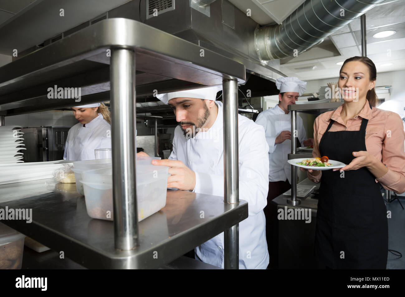 Head chef checking dishes in kitchen of restaurant before serving ...