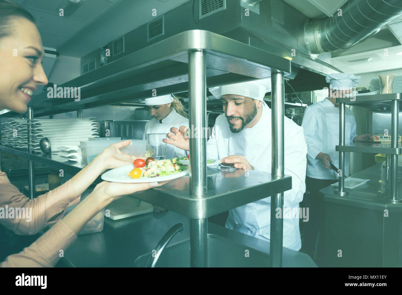 Staff of restaurant with head chef working together in kitchen Stock ...