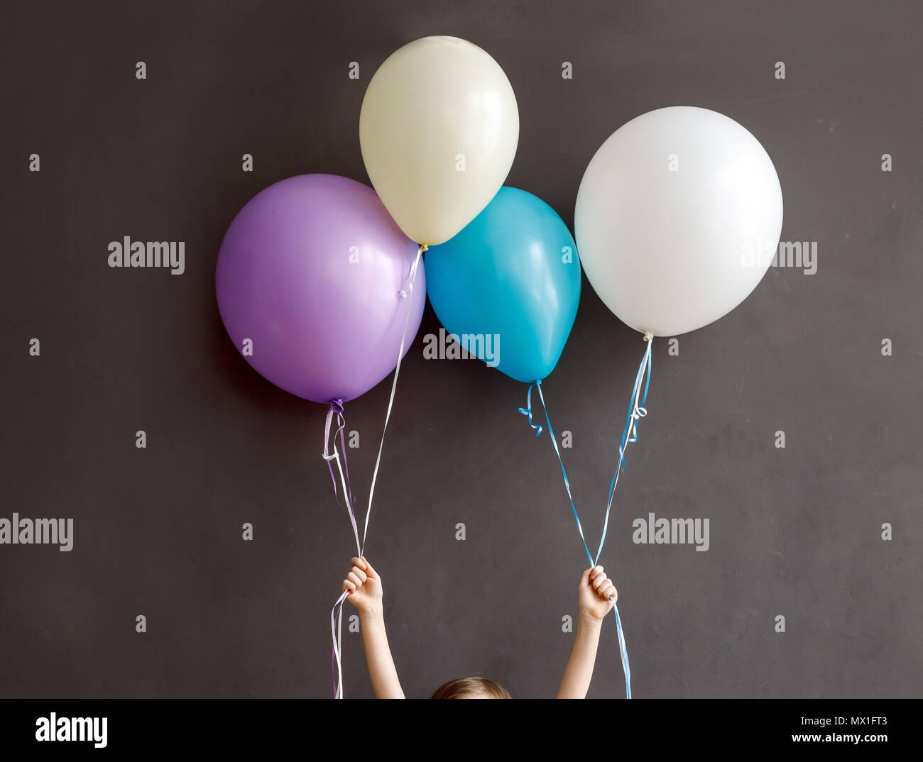 Little child holding colorful balloons Stock Photo - Alamy