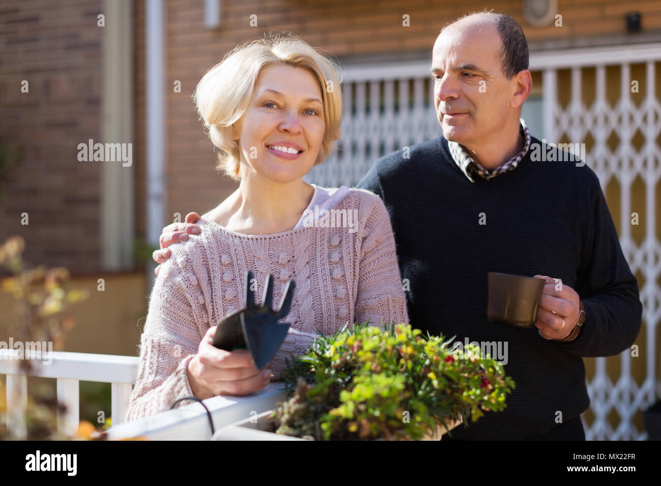 Mature happy female talking with male neighbor at balcon Stock Photo ...