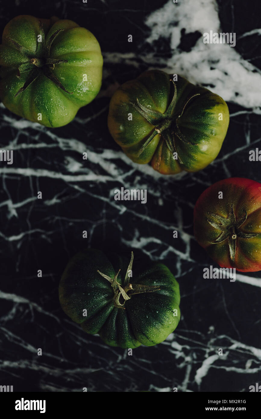 Moody tomatoes in a marble background Stock Photo - Alamy