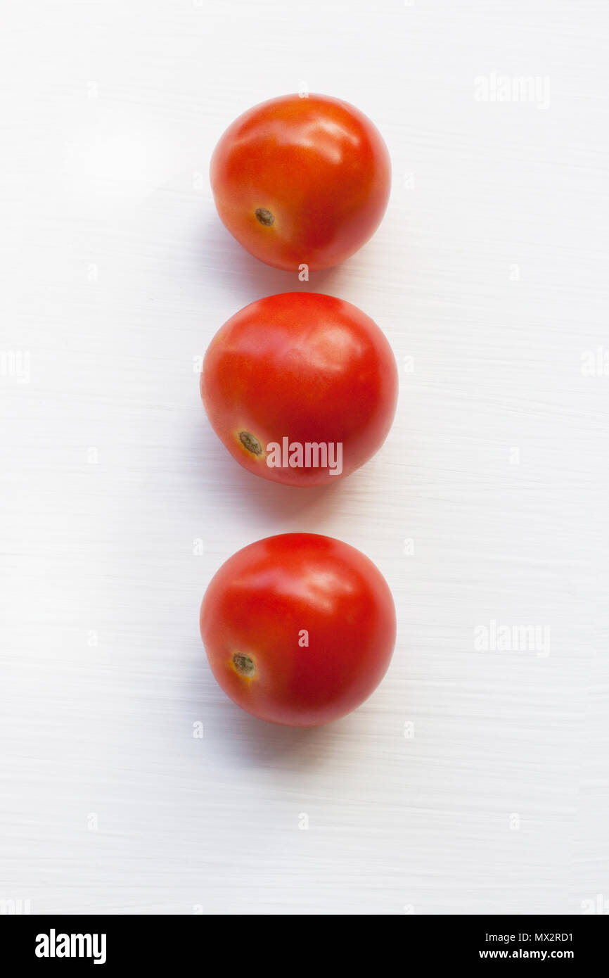 Three red tomatoes on a white background Stock Photo - Alamy