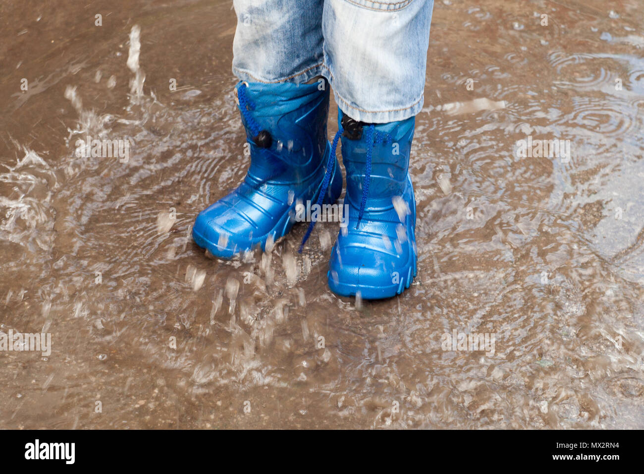 Kid child jumping puddle water splash hi-res stock photography and ...