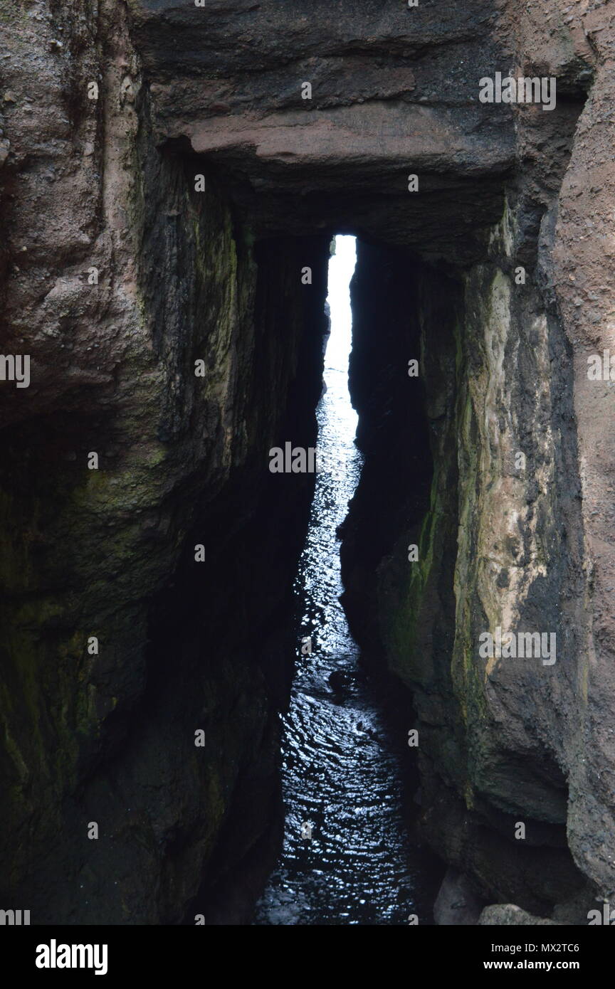 A gap in a cavern at the edge of the sea letting light into the dark ...