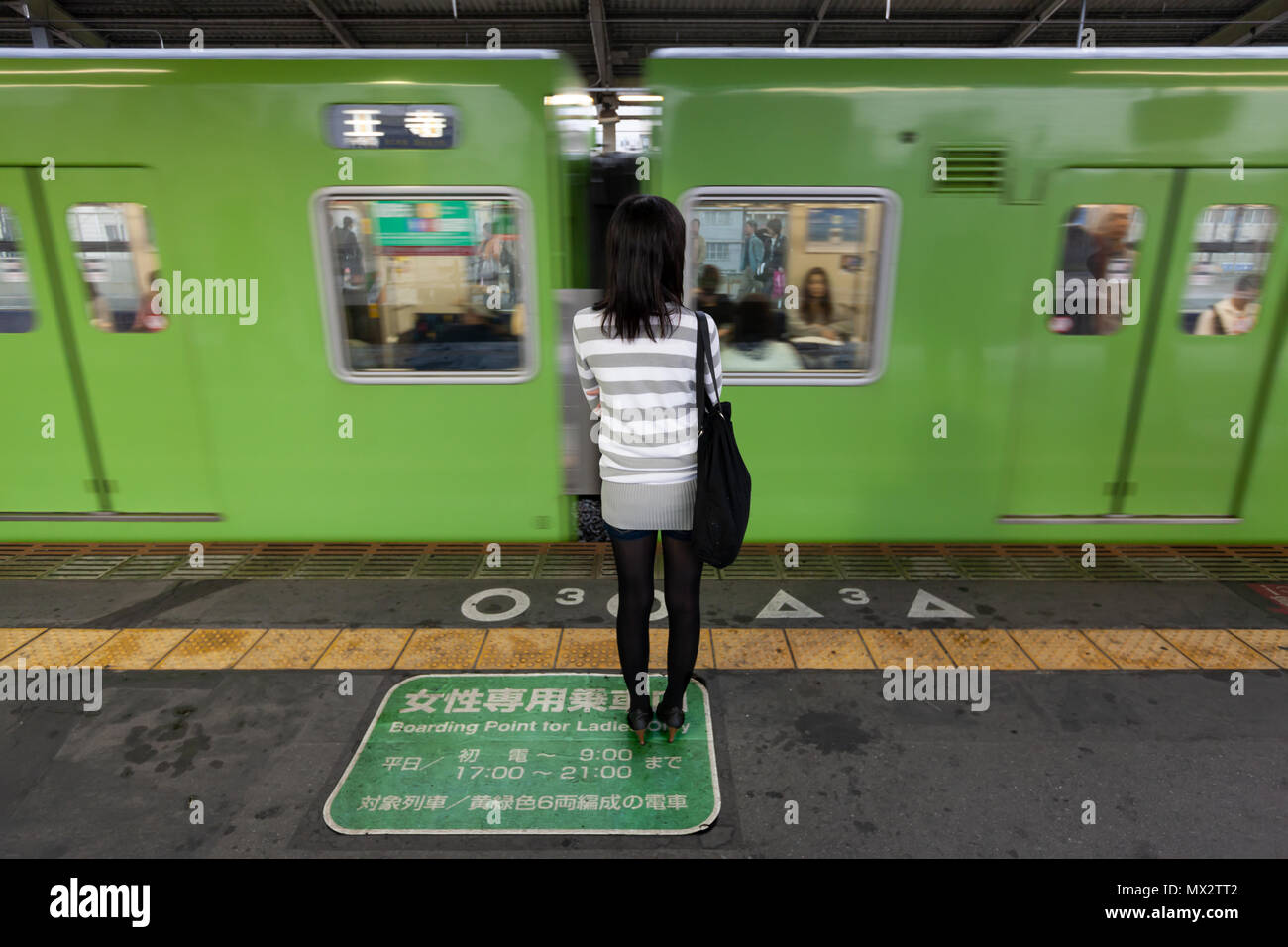 Japanese woman standing on the platform of a train station in a women ...