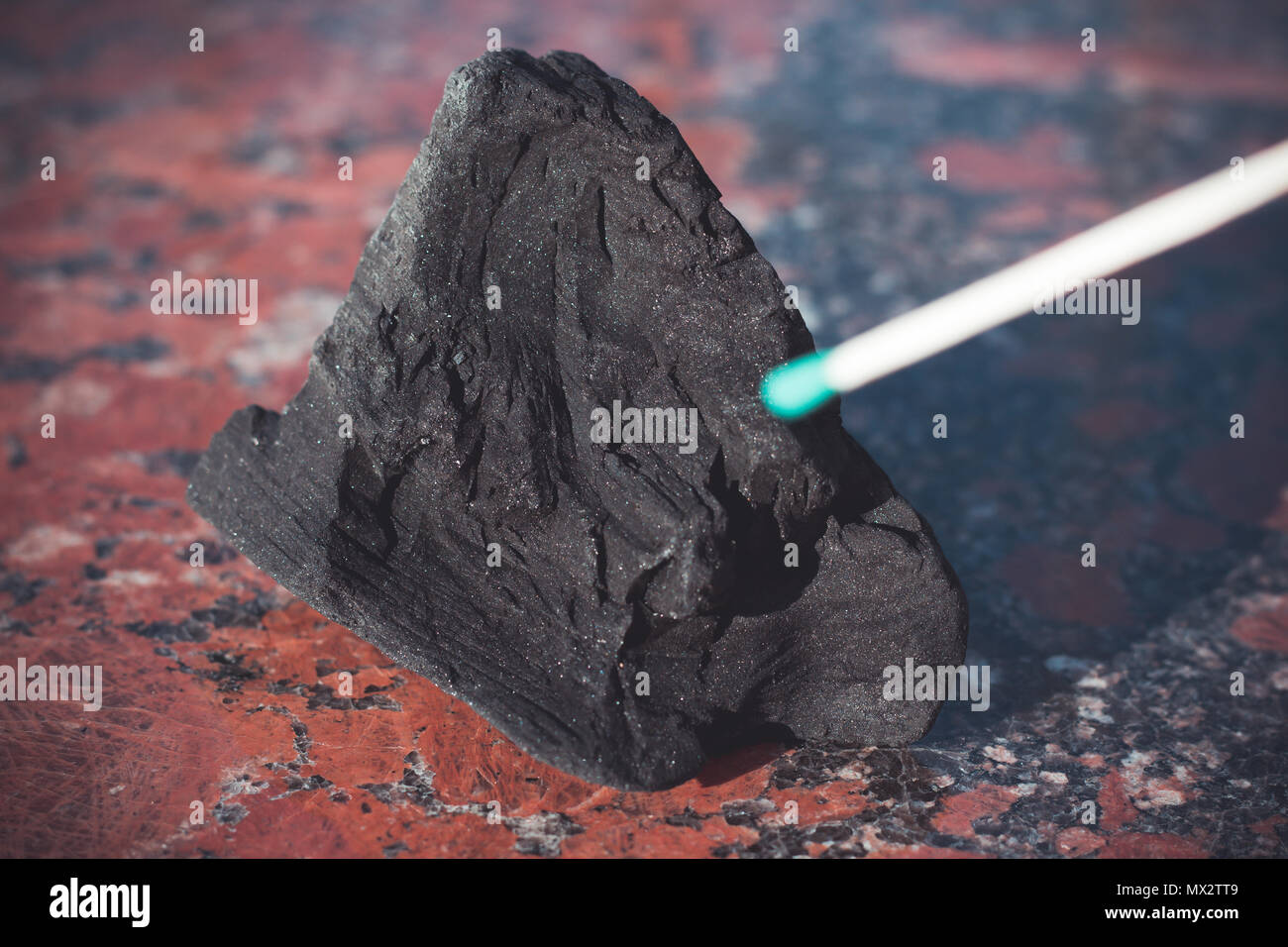 coal on a granite stone and a match, close-up Stock Photo - Alamy