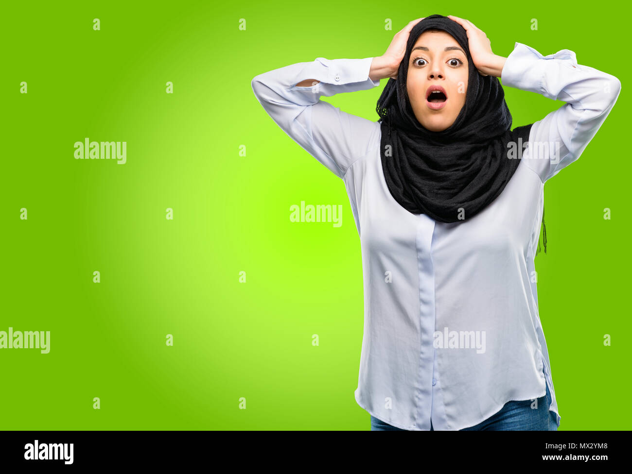 Young arab woman wearing hijab stressful keeping hands on head ...