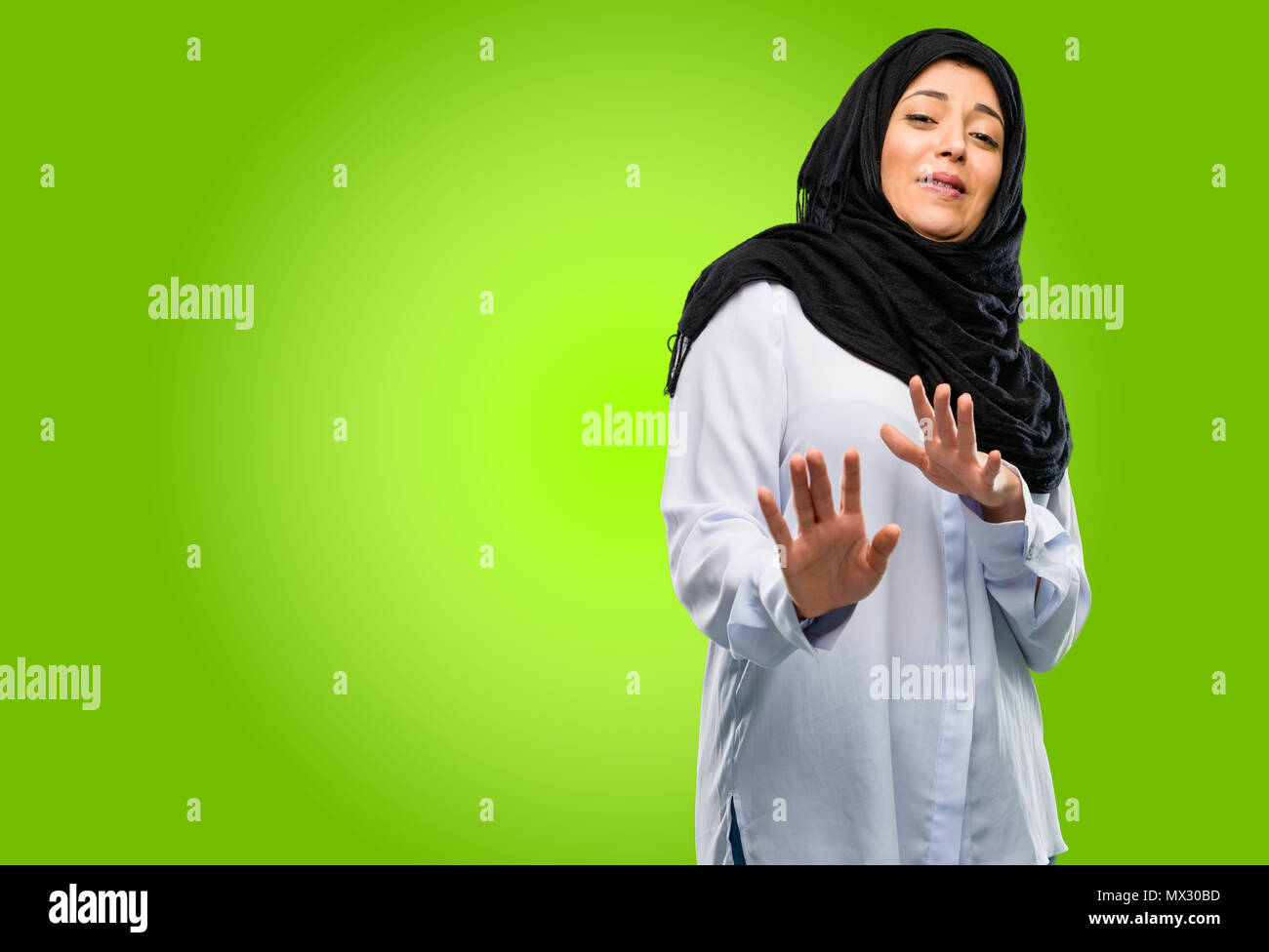 Young arab woman wearing hijab disgusted and angry, keeping hands in ...