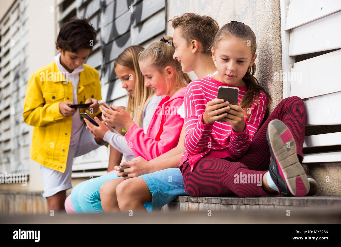 Five kids are playing on phone in the playground Stock Photo - Alamy