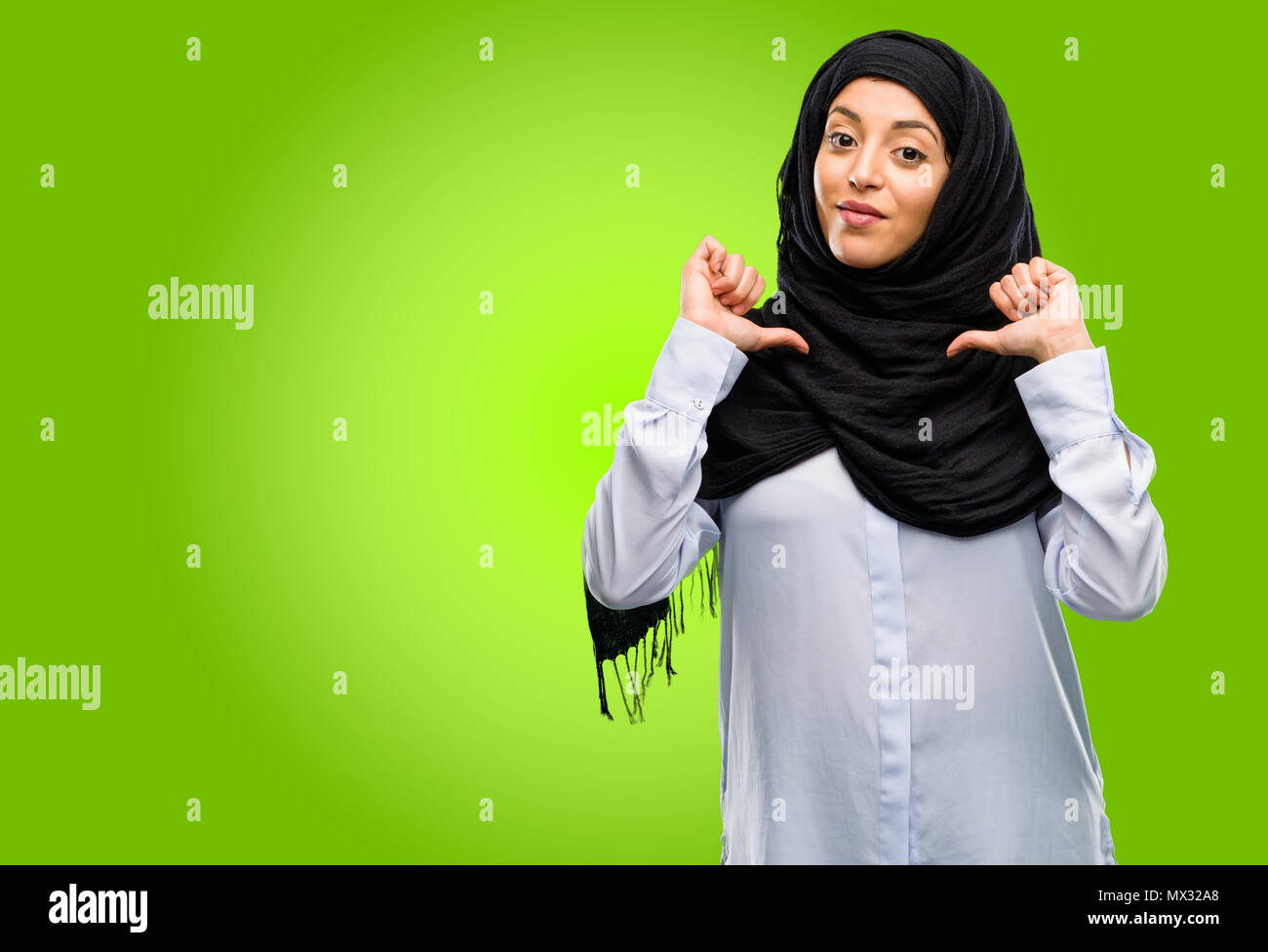 Young arab woman wearing hijab proud, excited and arrogant, pointing ...