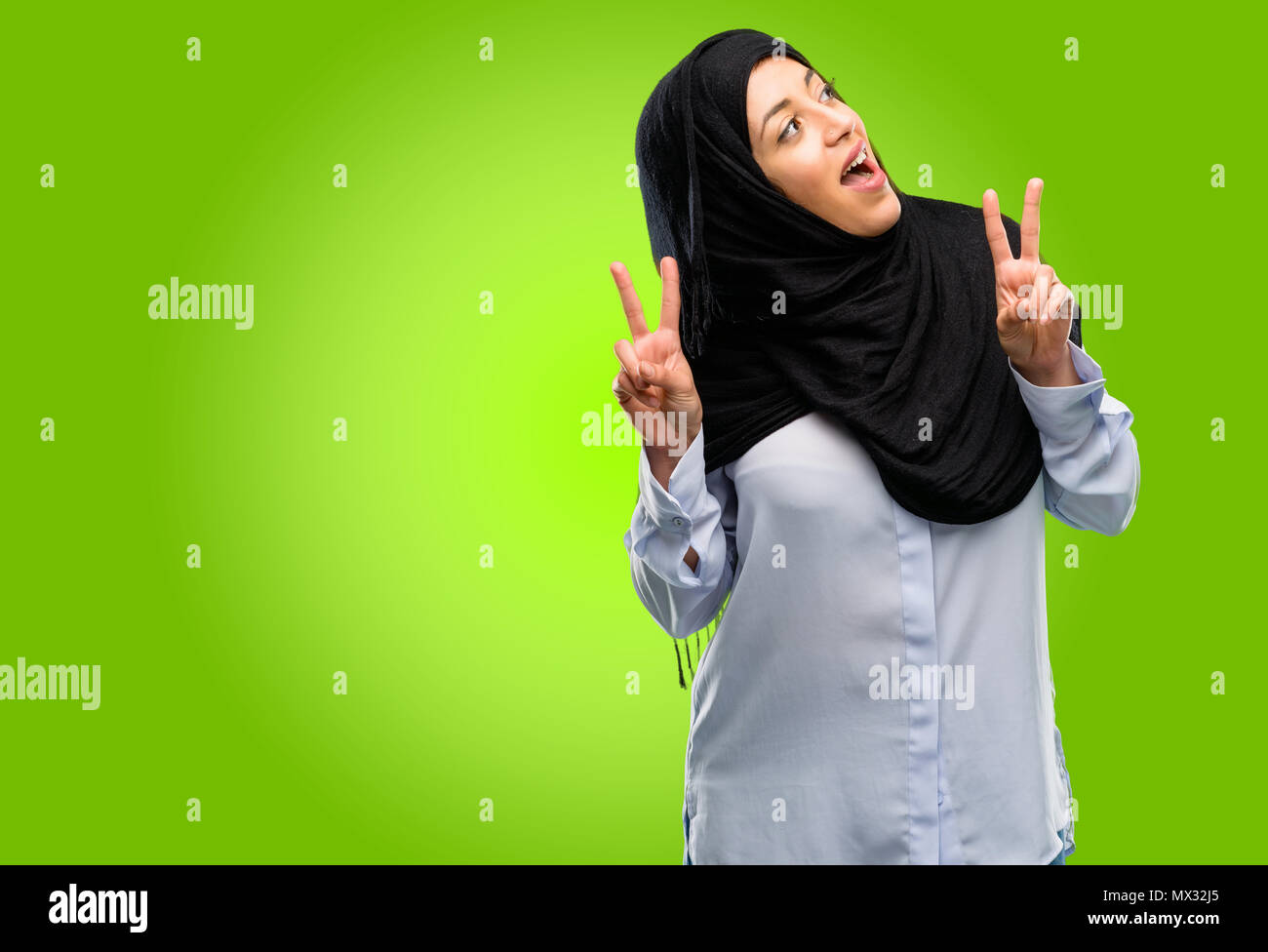 Young arab woman wearing hijab happy and excited expressing winning ...