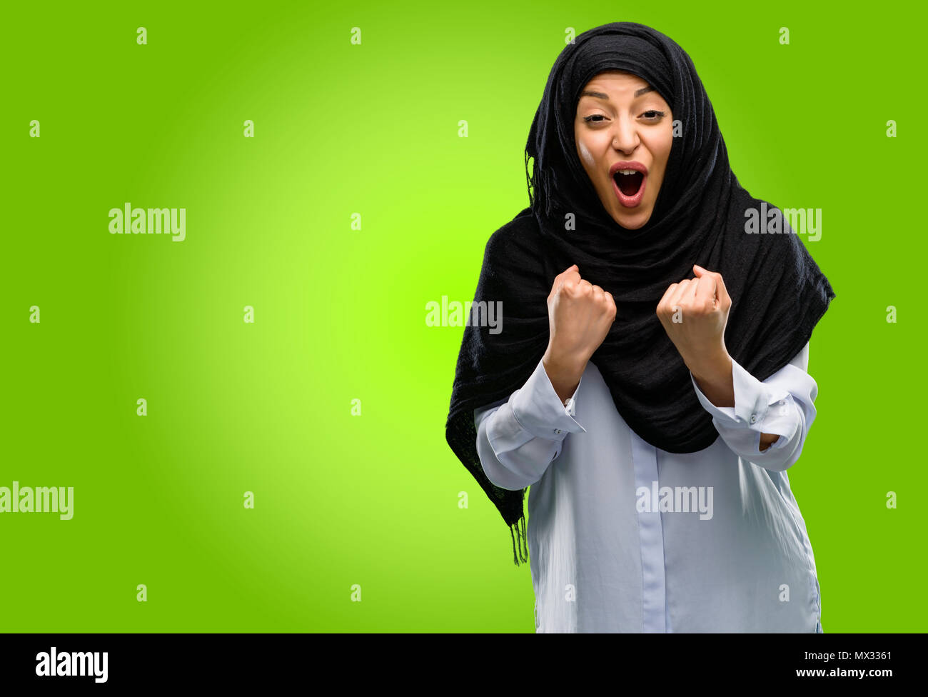 Young arab woman wearing hijab happy and excited celebrating victory ...