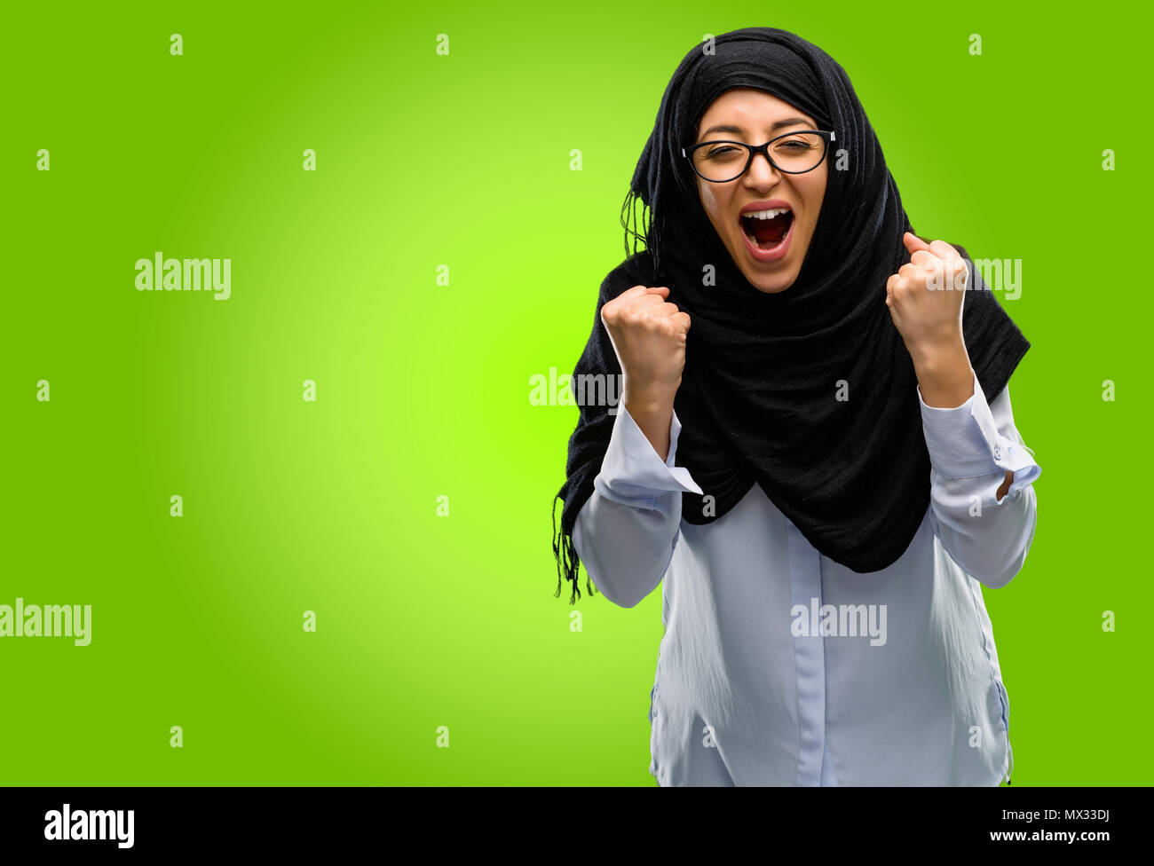 Young arab woman wearing hijab happy and excited celebrating victory ...